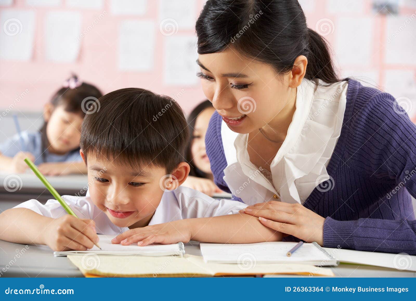 Helping Student Working at Desk in Chinese School Stock Photo - Image ...