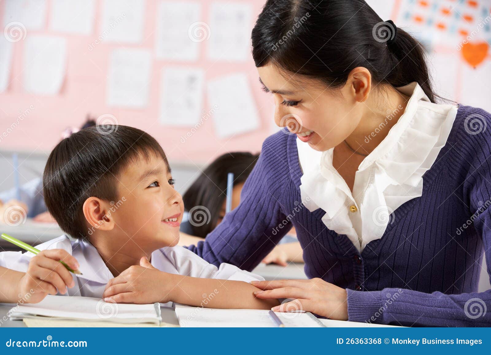 Helping Student Working at Desk in Chinese School Stock Photo - Image ...