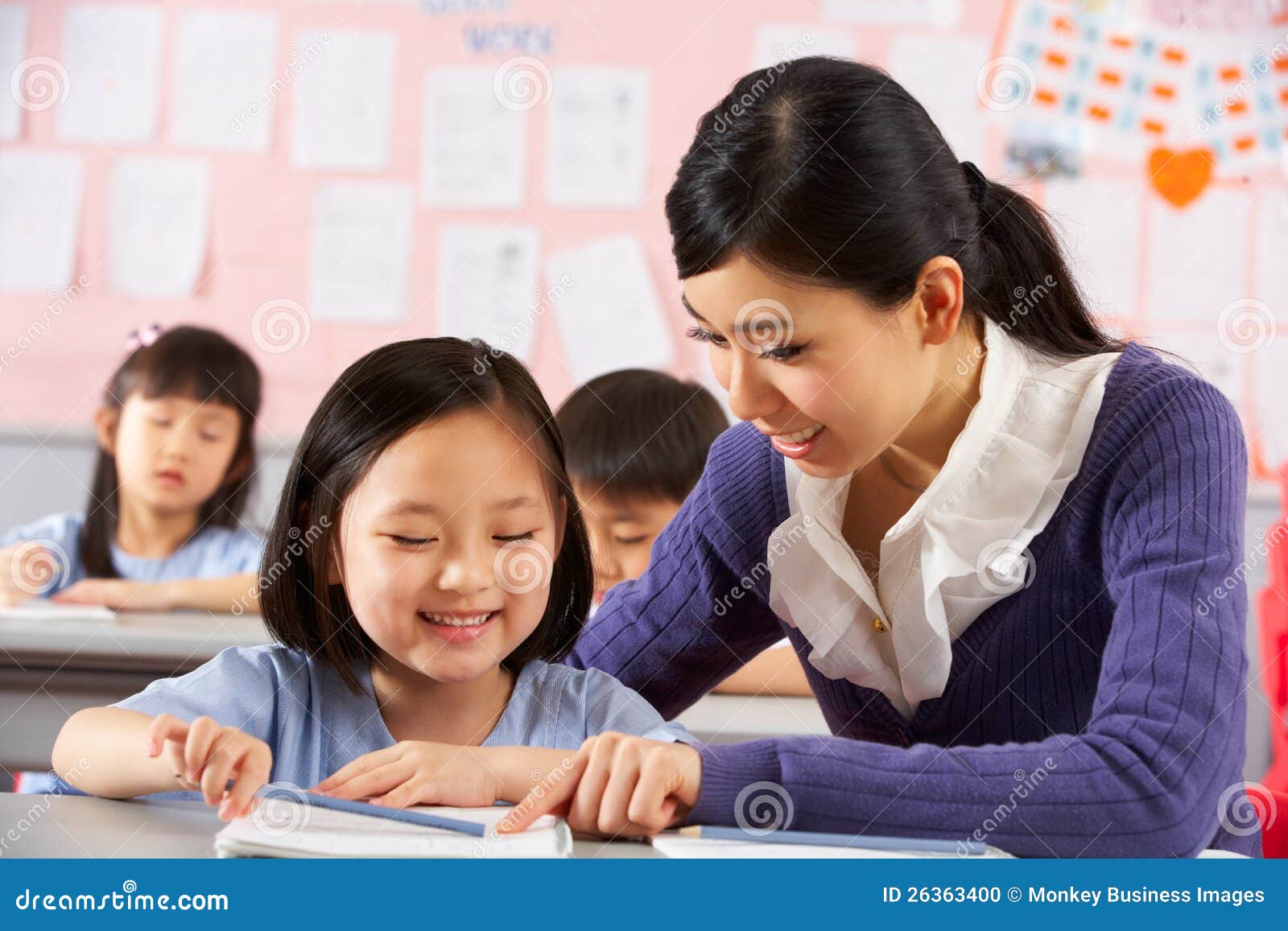 Helping Student Working at Desk in Chinese School Stock Photo - Image ...