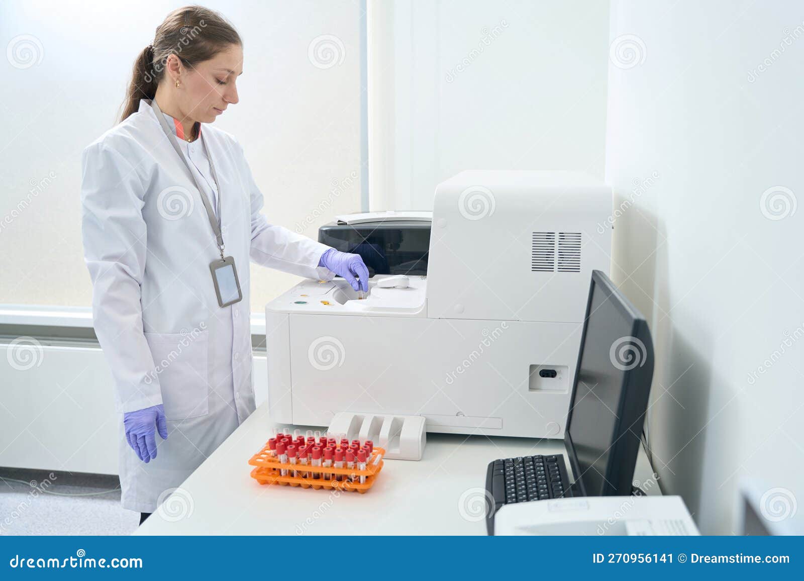 Hematologist Laboratory Assistant Stands Near an Immunochemiluminescent ...
