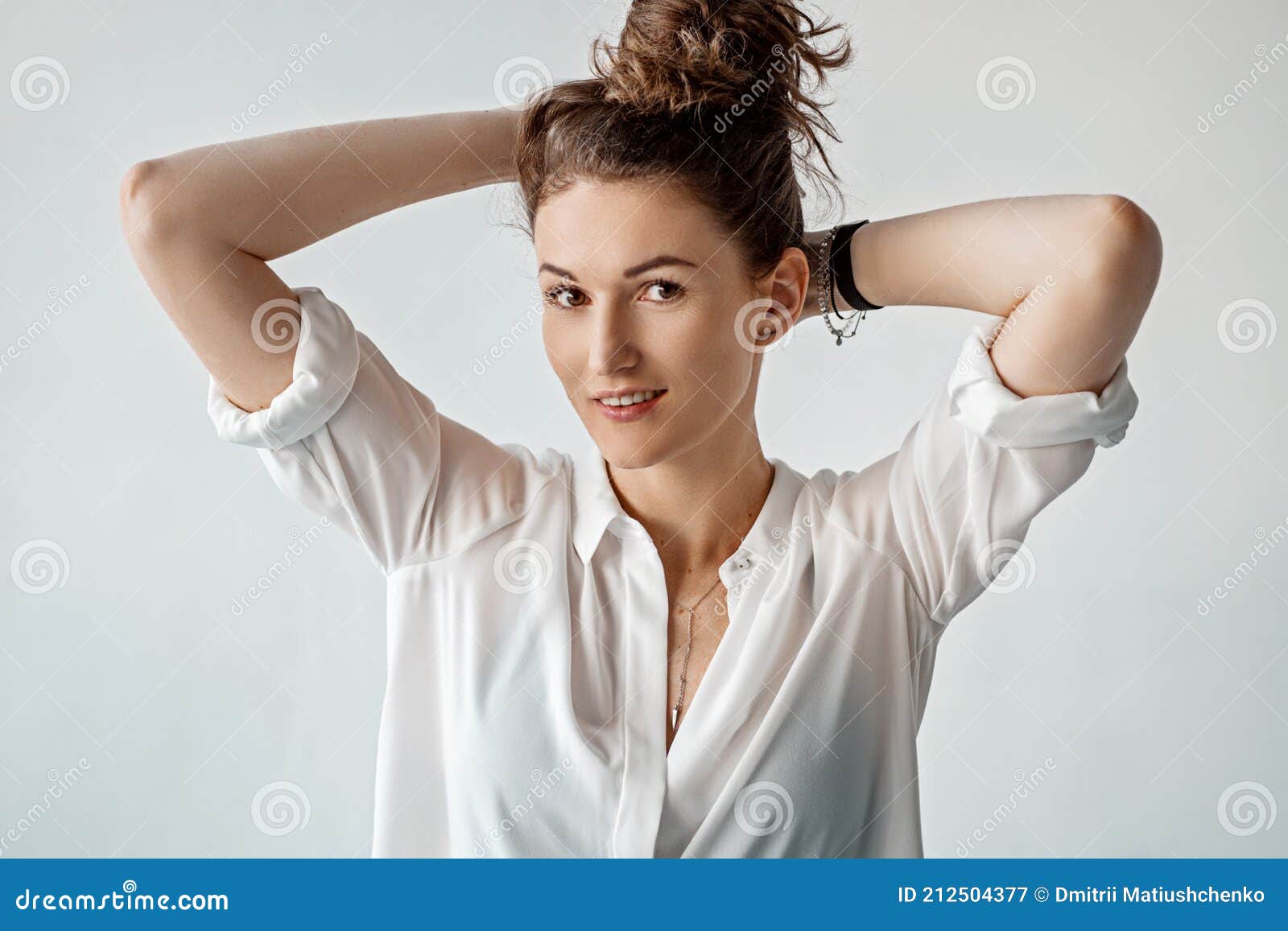 Hermosa Chica En Ropa Blanca Se Sienta En El Suelo Sobre Un Fondo Blanco Imagen De Archivo
