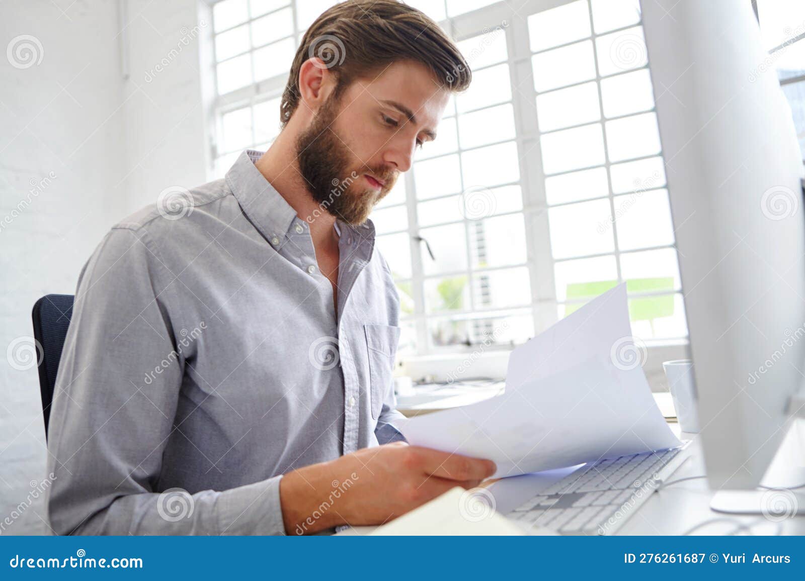 Hes the Admin Master. a Young Designer Holding Paperwork while Sitting ...
