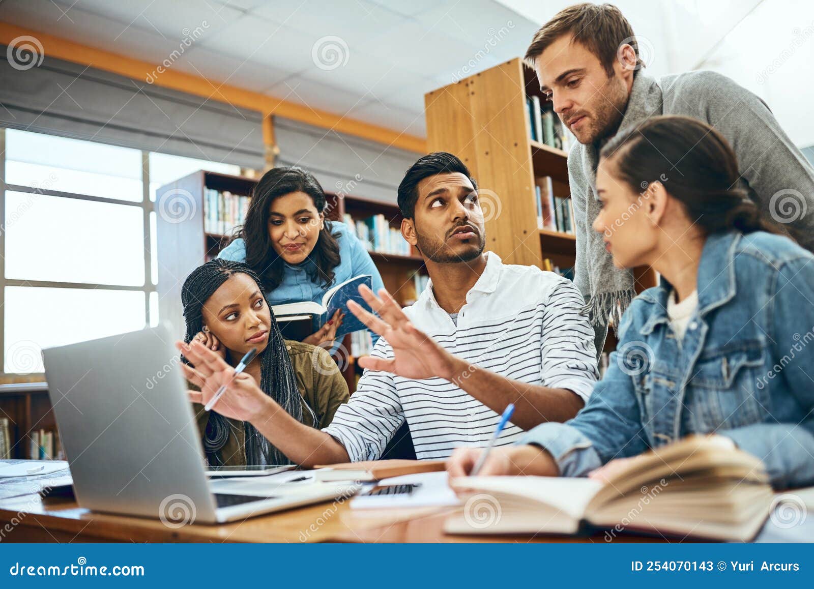 Hes a Great Tutor. a Group of University Students Studying in the ...