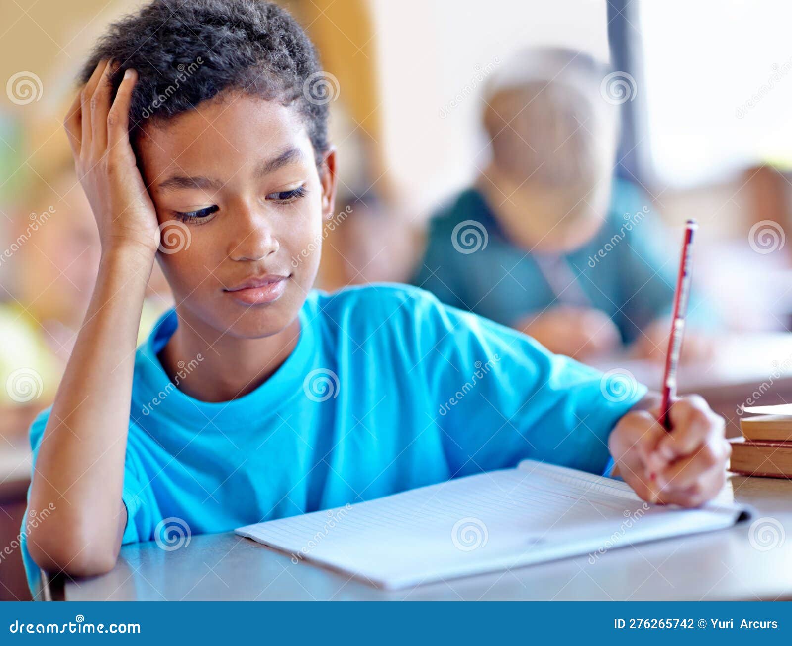Hes Studying Hard. a Young Boy Taking Notes while Sitting in Class ...