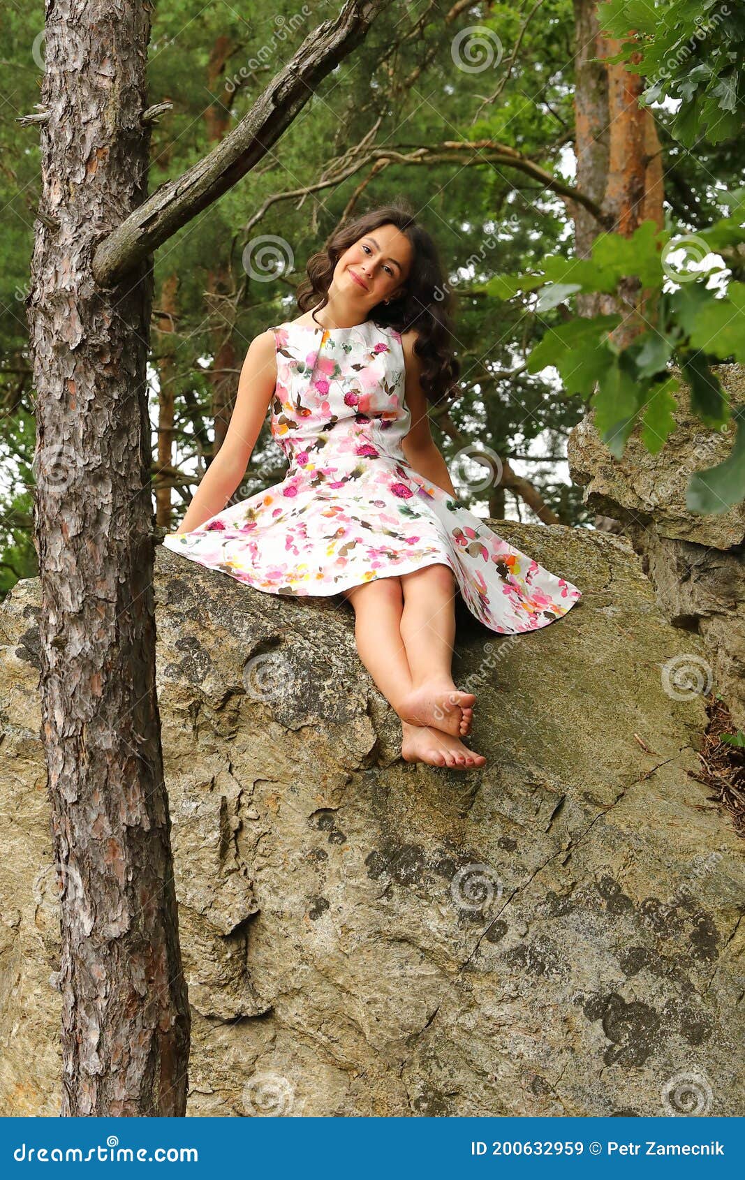Het Glimlachende Tienermeisje Dat Op Rots In Het Bos Zit Stock