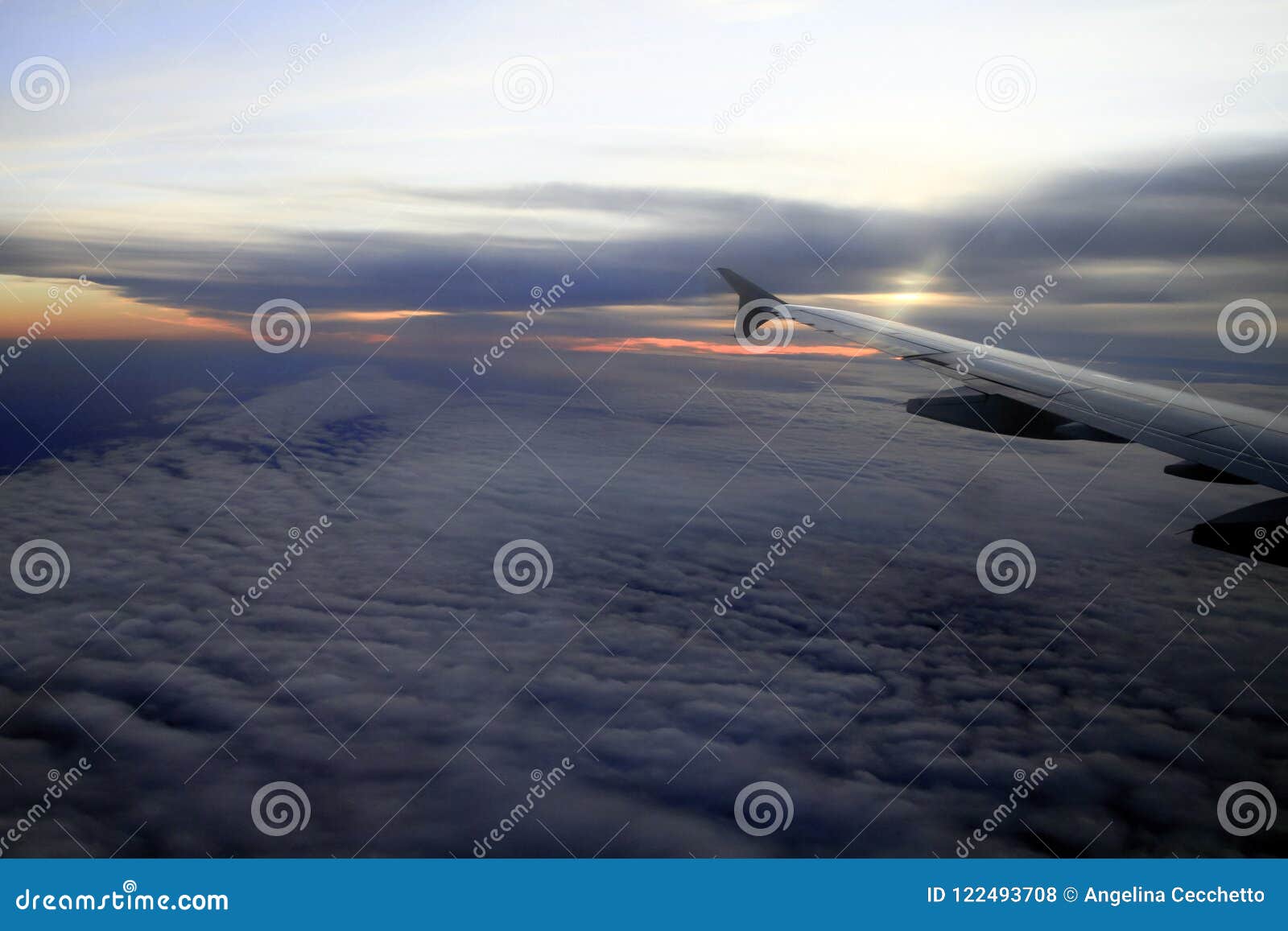 High Altitude Sunset Over the Clouds from a Plane Window Stock Photo ...