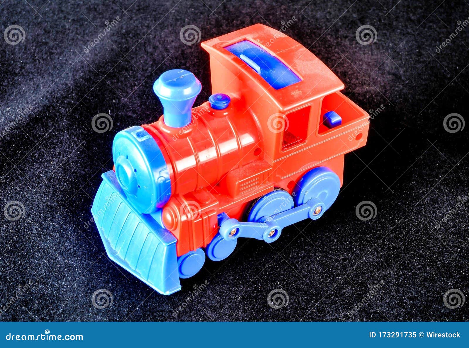 High Angle Closeup Shot of a Red and Blue Toy Train on a Black Surface ...