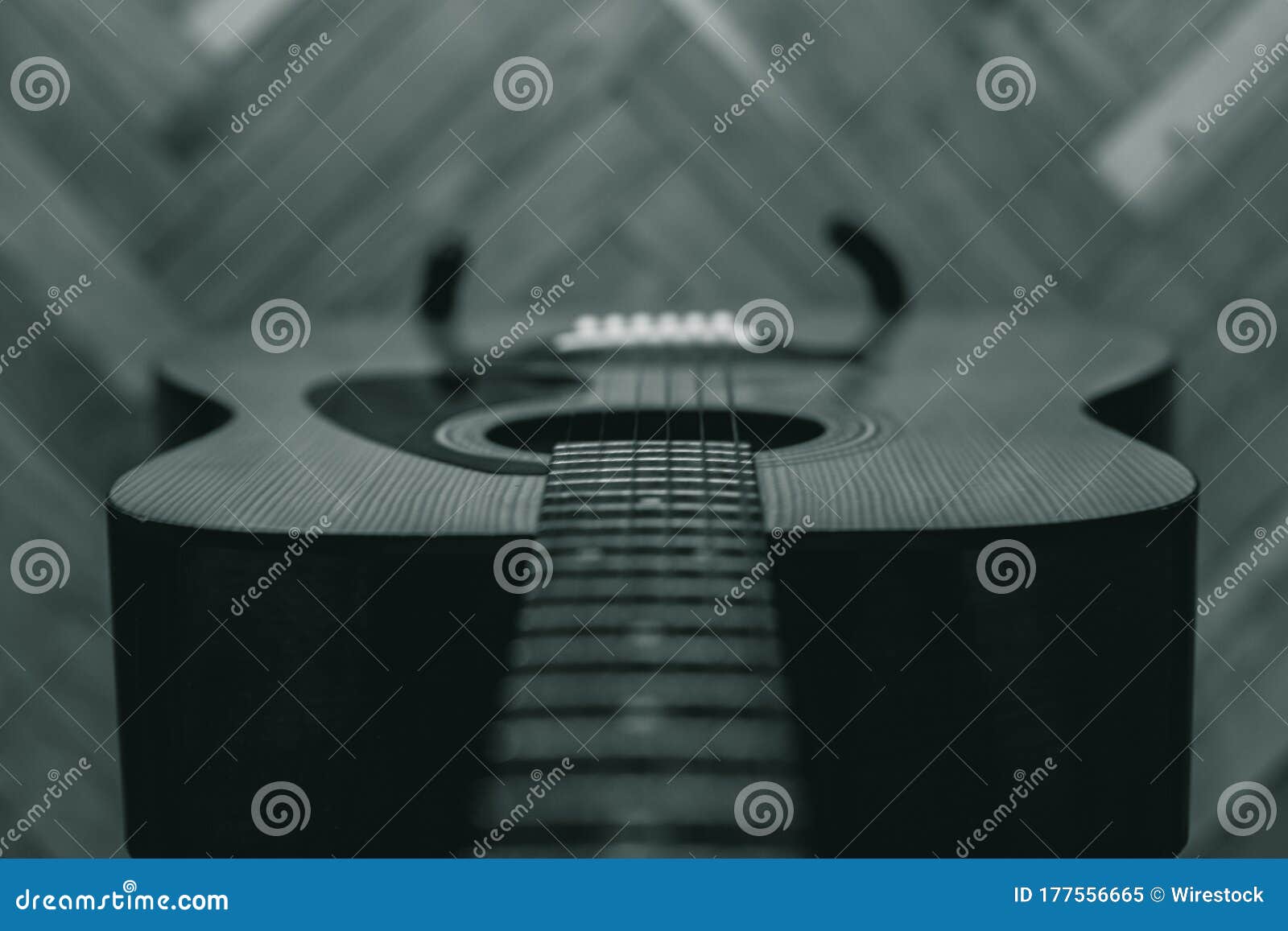 High Angle Greyscale of an Acoustic Guitar on a Stand on the Floor ...