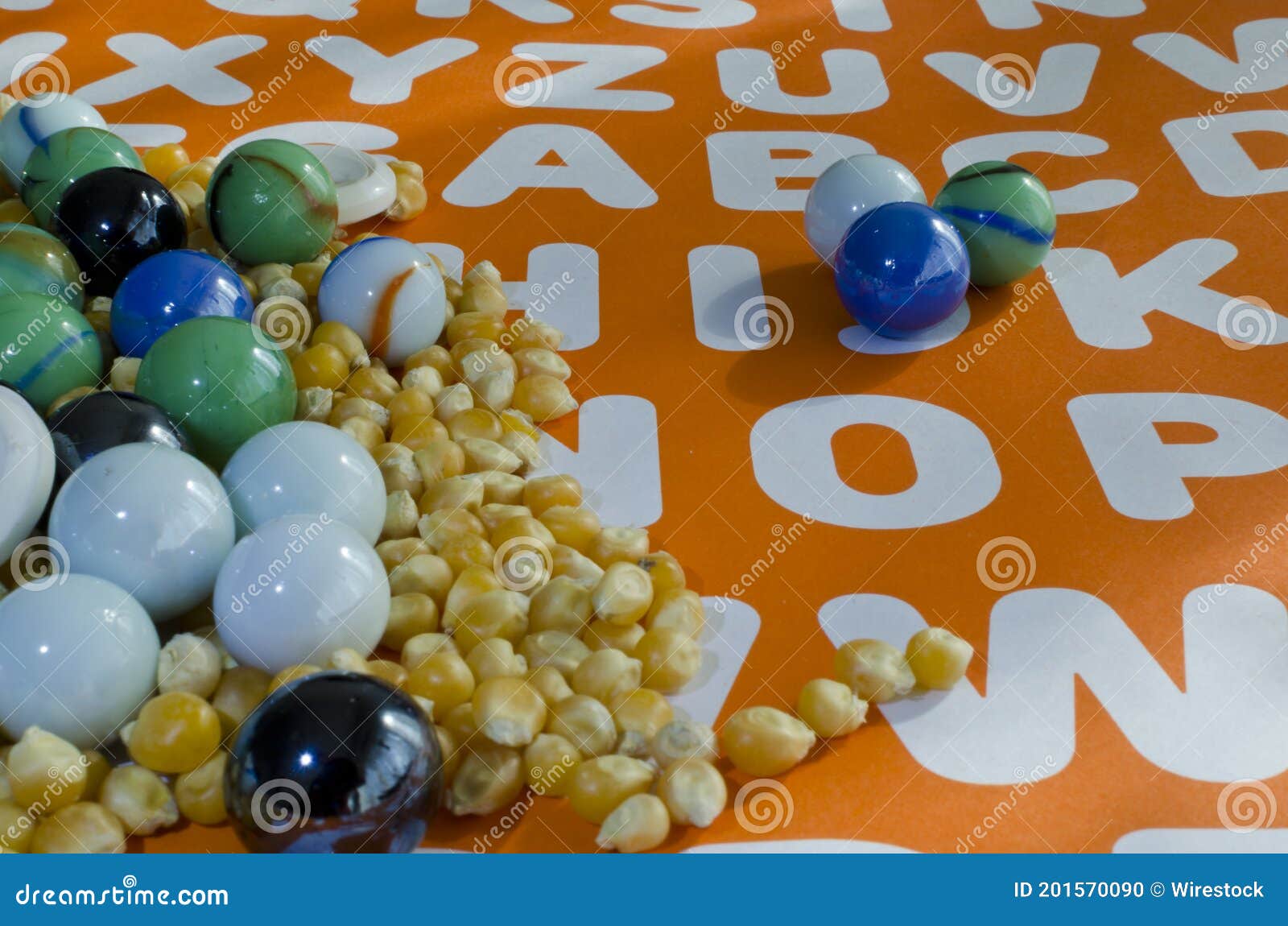 High Angle Shot of Colorful Marbles and Corn Kernels on an Orange ...