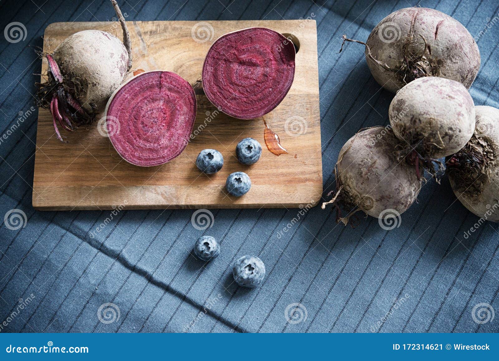 High Angle Shot of Cut and Whole Beetroot with Berries on a Chopping ...