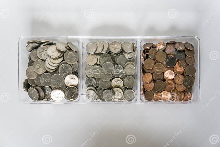 High Angle Shot of Different Coins in Plastic Containers on a White ...