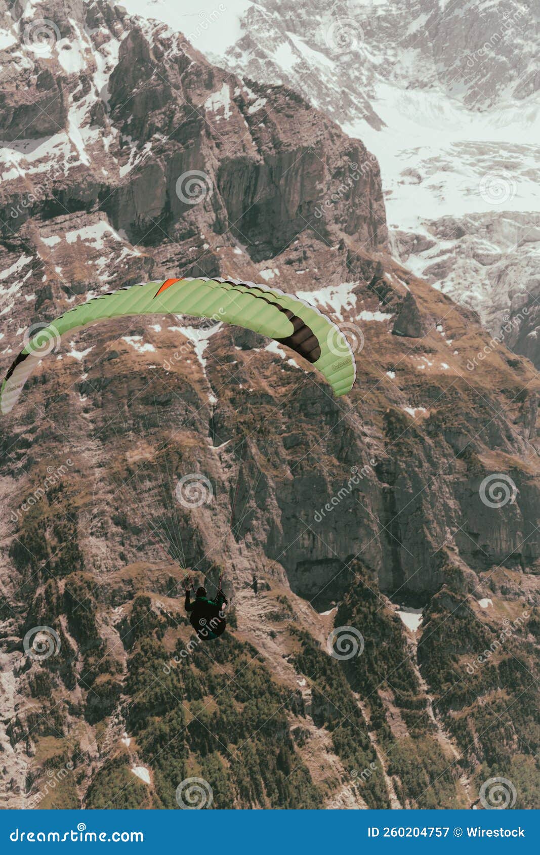 High Angle Shot of a Man Paragliding in the Air on the Background of ...