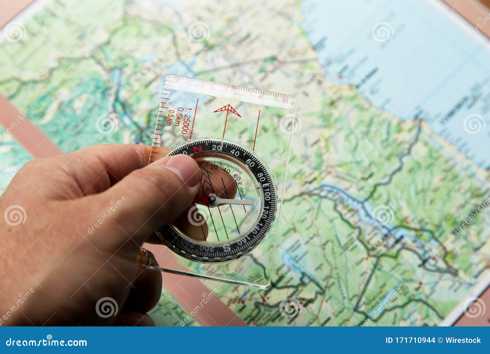 High Angle Shot of Person Holding a Compass Over a Geographical Map ...