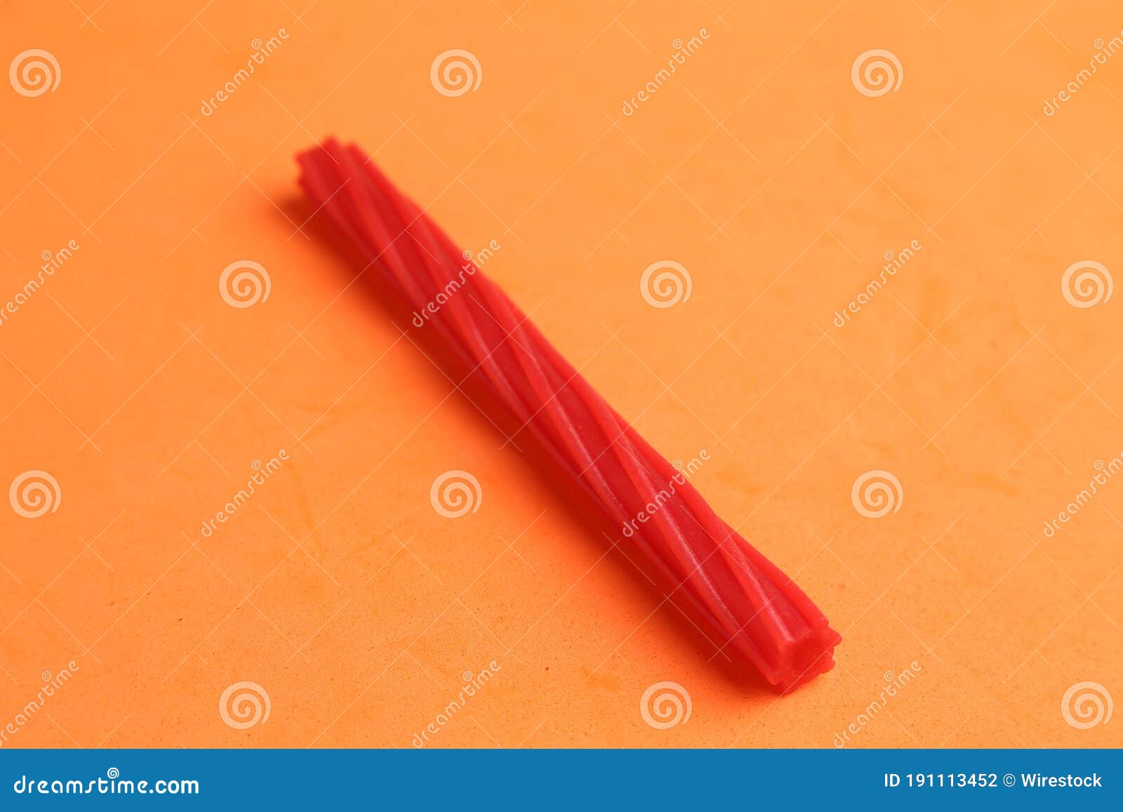 High Angle Shot of a Red Licorice Stick Isolated on an Orange ...
