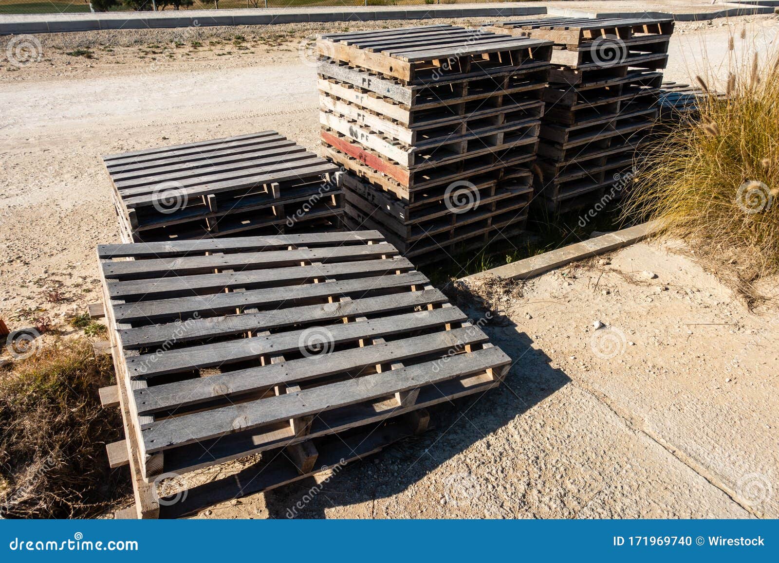 High Angle Shot of a Stack of Wood Pallets at the Side of a Dusty Road ...