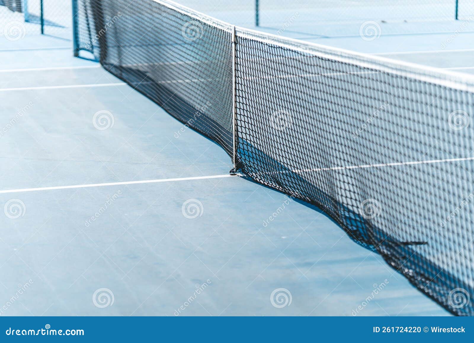 High-angle of a Sunlit, Blue Tennis Court with a Net Stock Photo ...