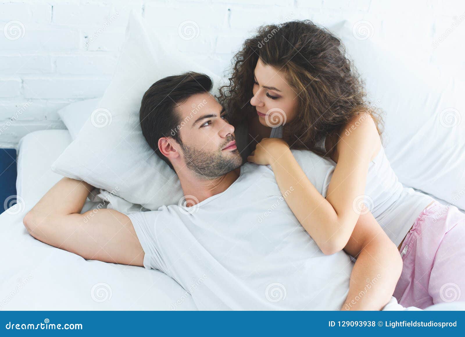 High Angle View of Beautiful Young Couple in Love Lying in Bed and ... High Angle View of Beautiful Young Couple in Love Lying in Bed and ...