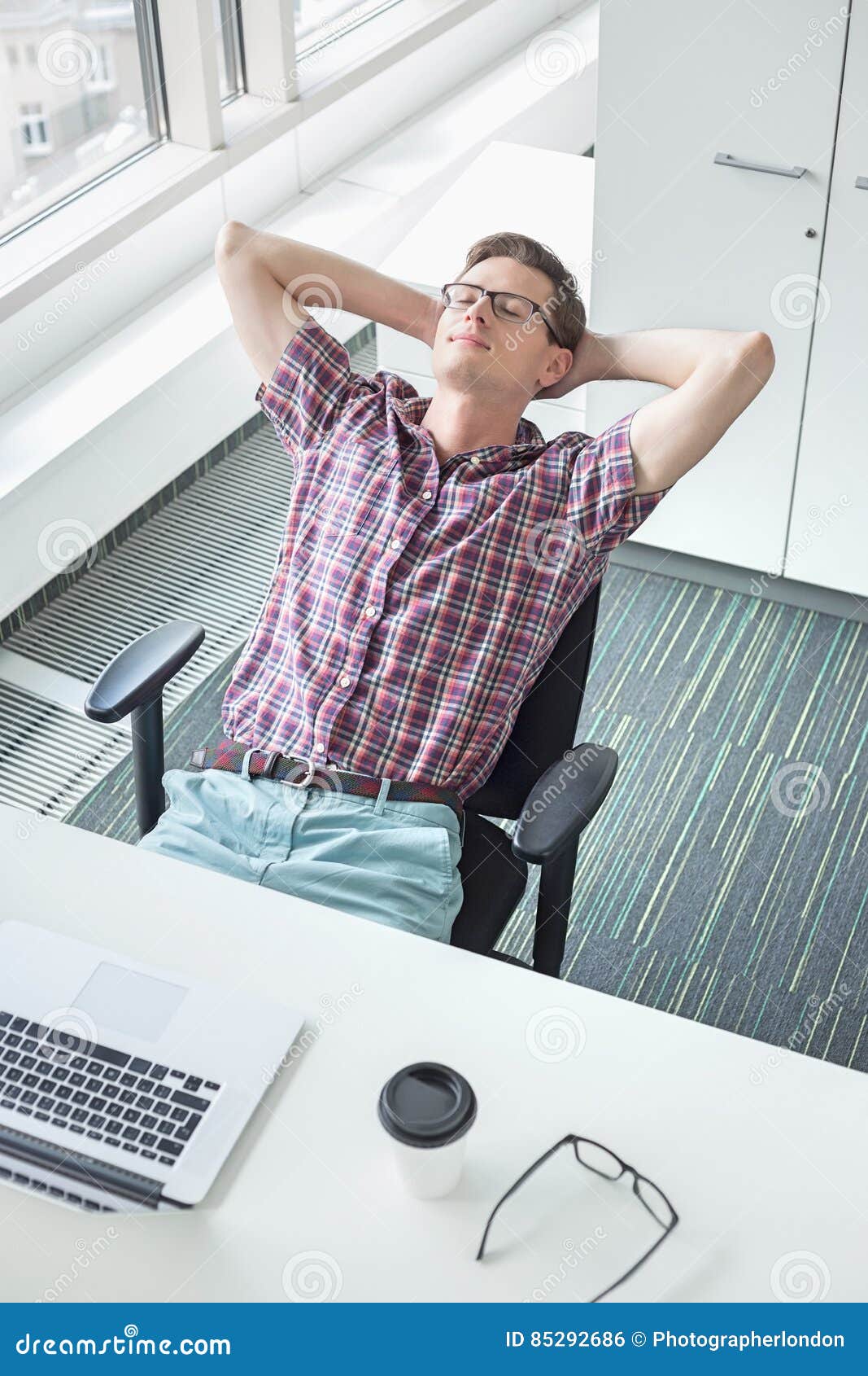 High Angle View of Businessman Relaxing at Desk in Creative Office ...