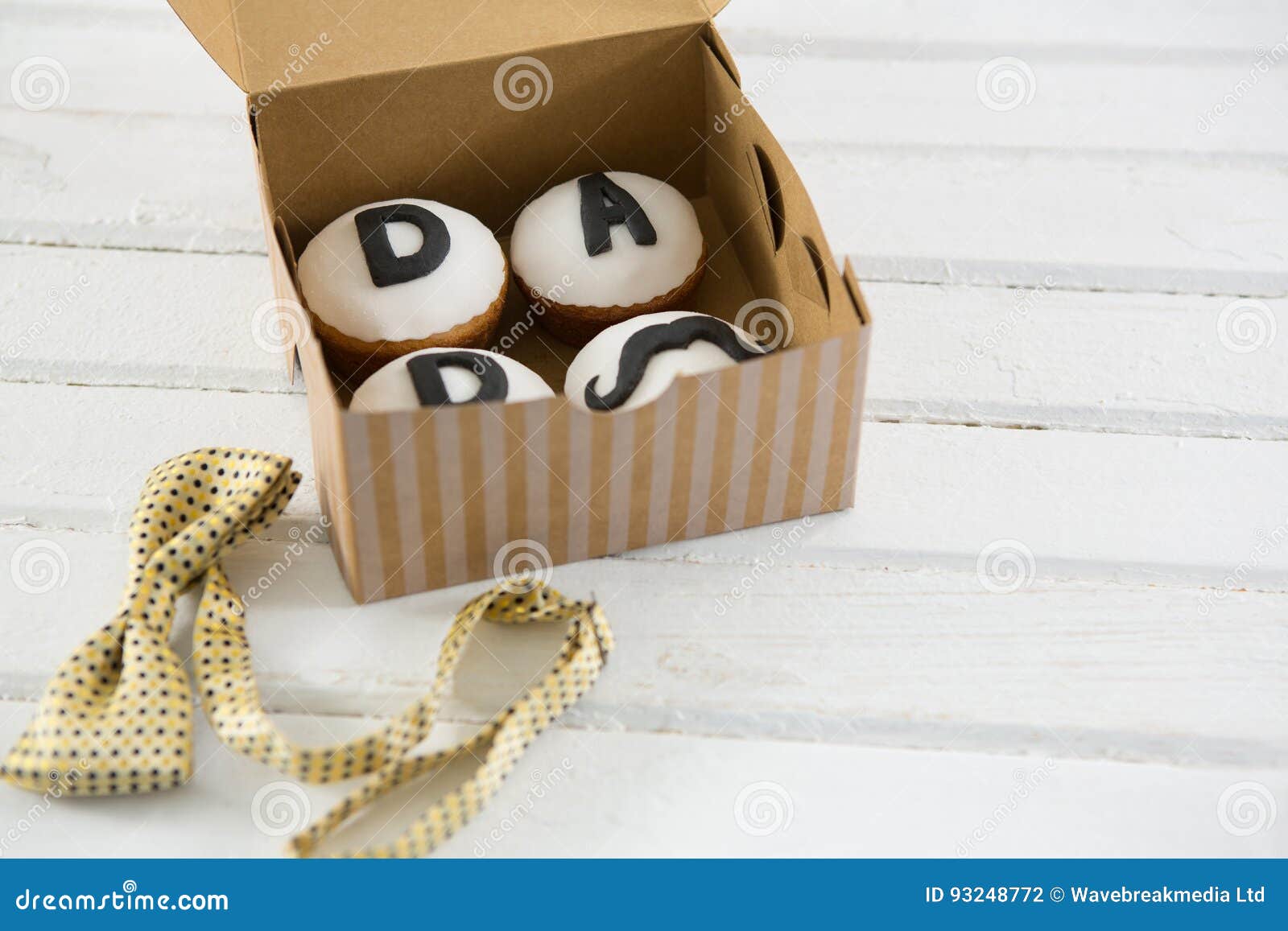 High Angle View of Cupcakes with Text in Box by Bow Tie Stock Photo ...