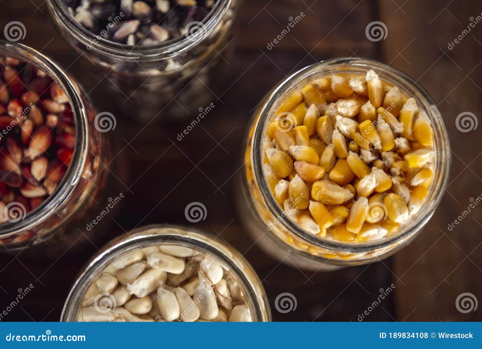 High Angle View of Different Types of Corn Kernels in Jars on a Wooden ...