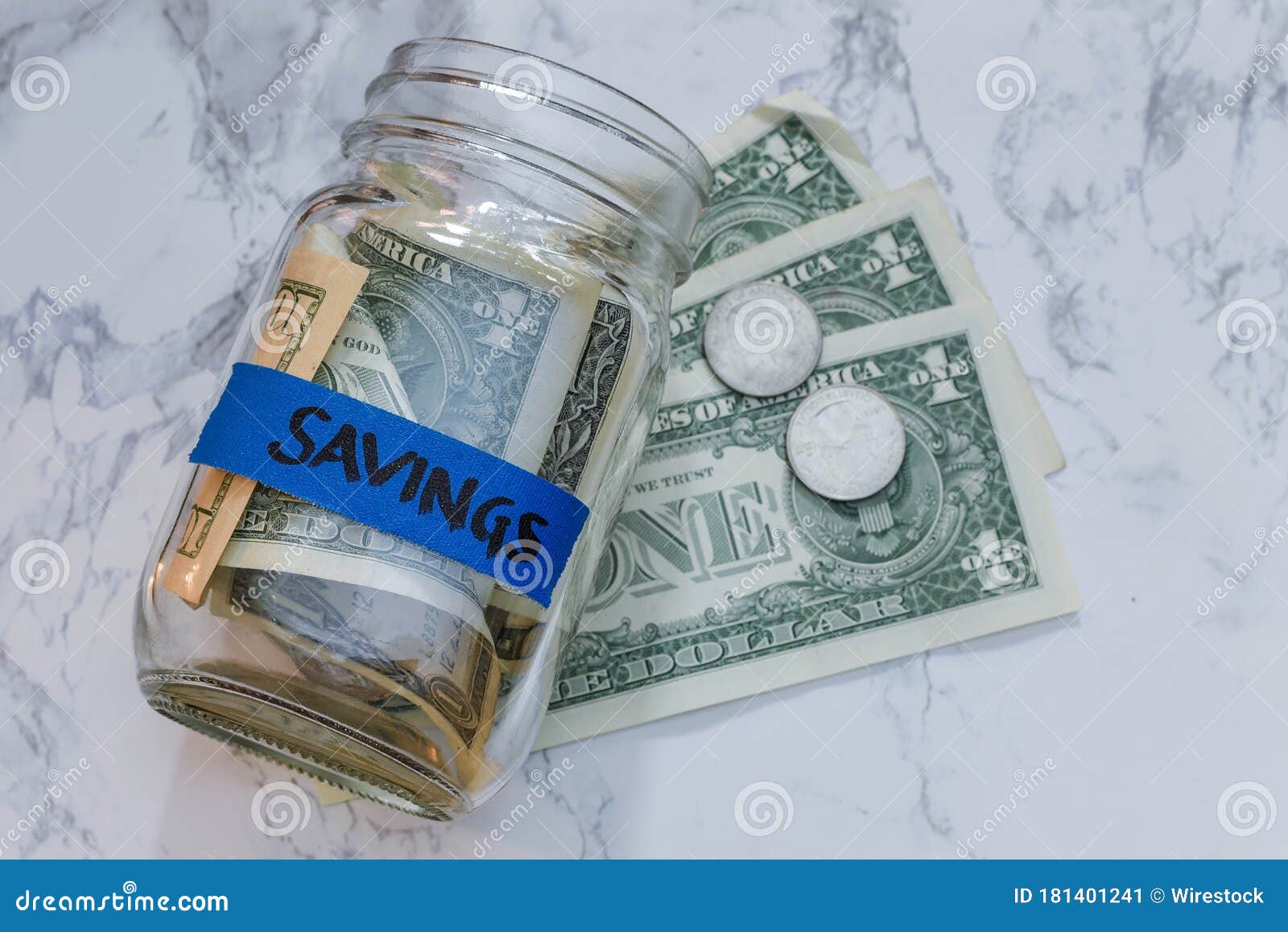 High Angle View of Dollars and Coins in a Jar with a Blue [savings ...