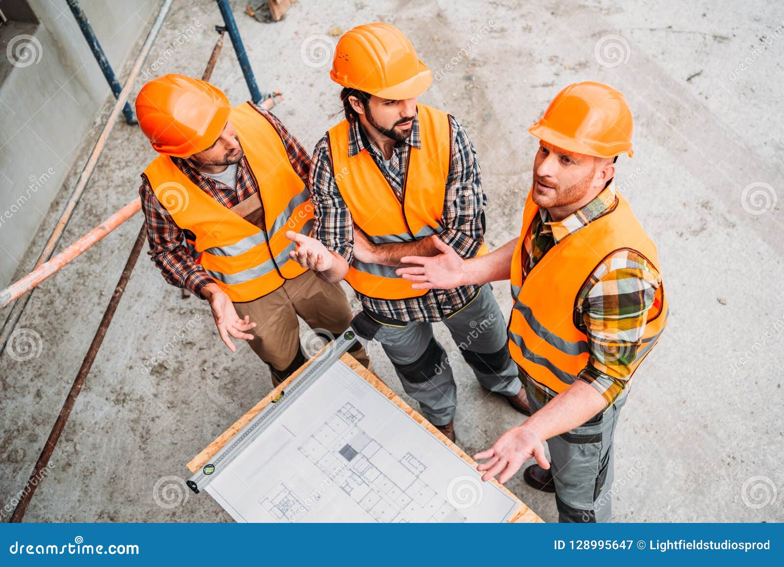 High Angle View of Group of Confused Builders Discussing Building Plan ...
