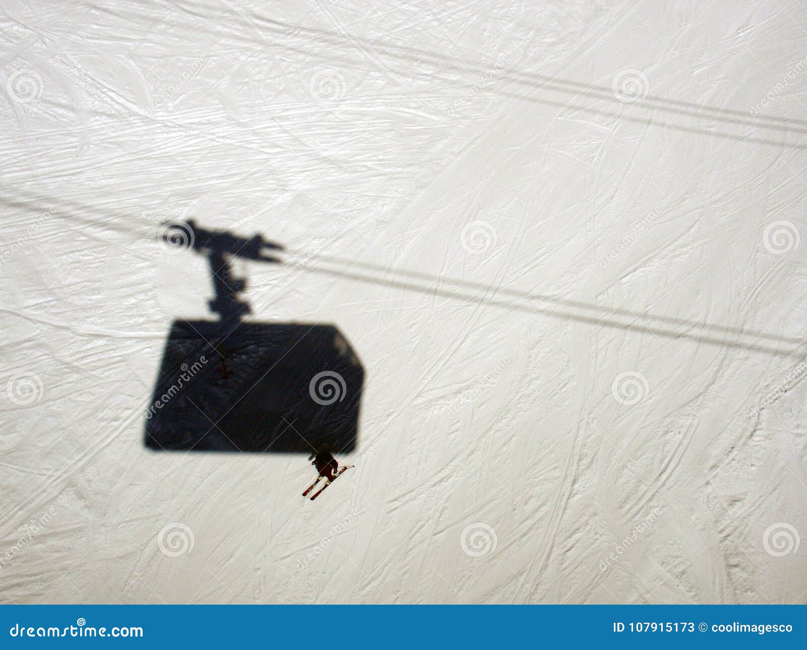 A High Angle View of a Guy Skiing and a Shadow of Ski Lift in the Alps ...