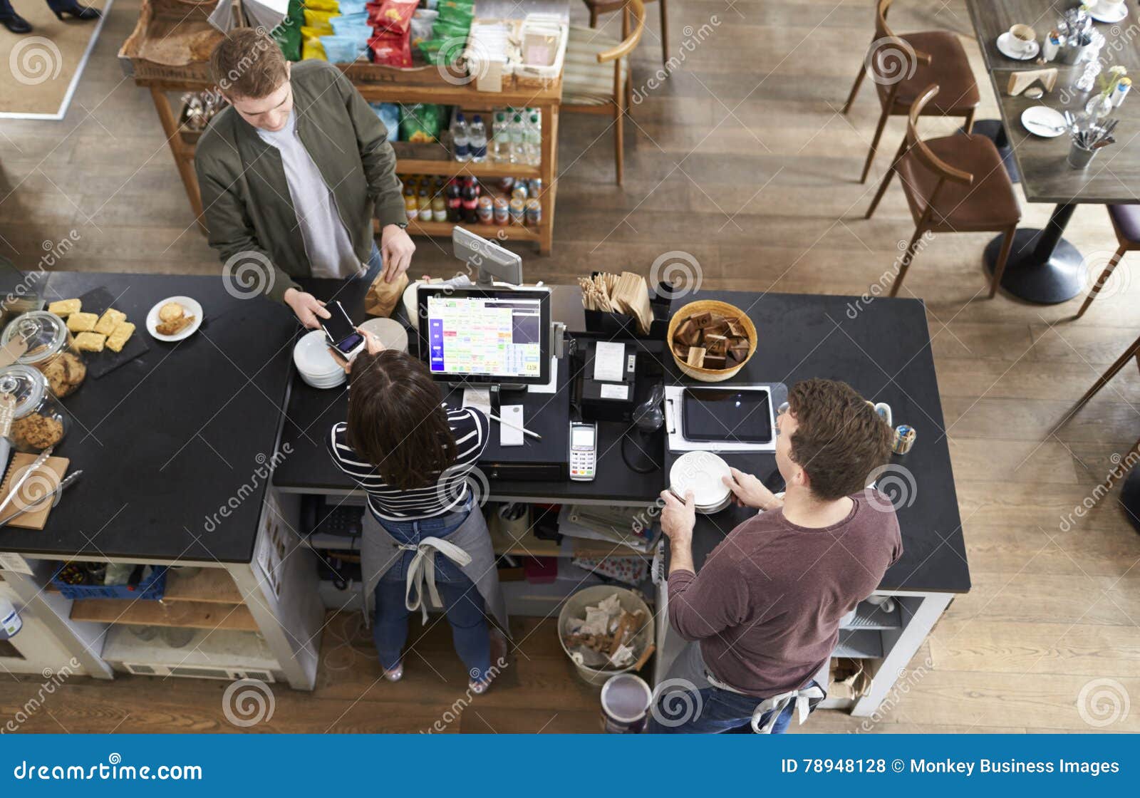 High Angle View of Man Paying Over Counter at a Coffee Shop Stock Photo ...