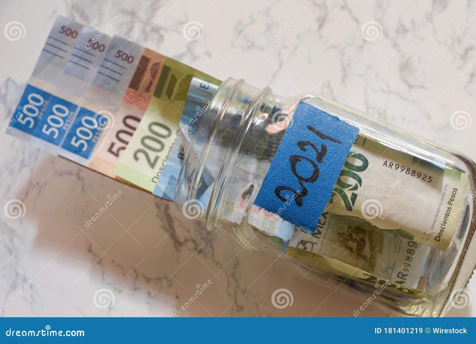 High Angle View of Pesos in a Jar with a Blue [2021] Sticker on it on ...