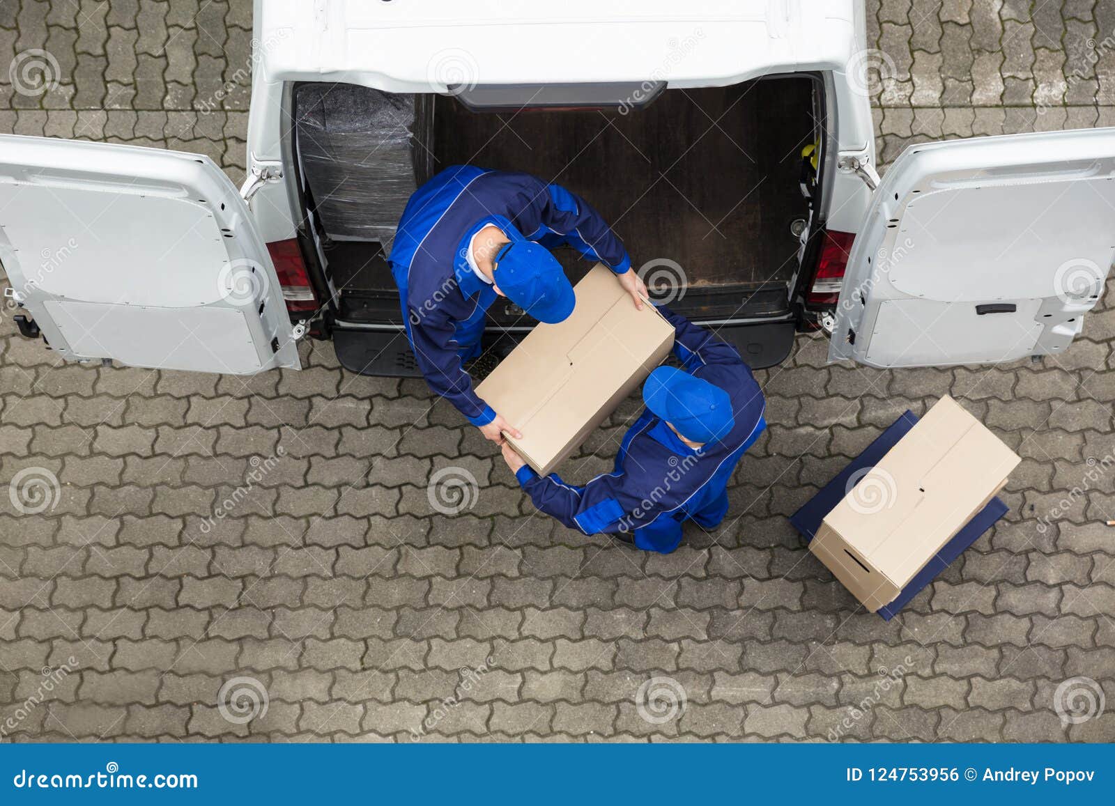 Two Delivery Men Unloading Cardboard Box from Truck Stock Photo - Image ...