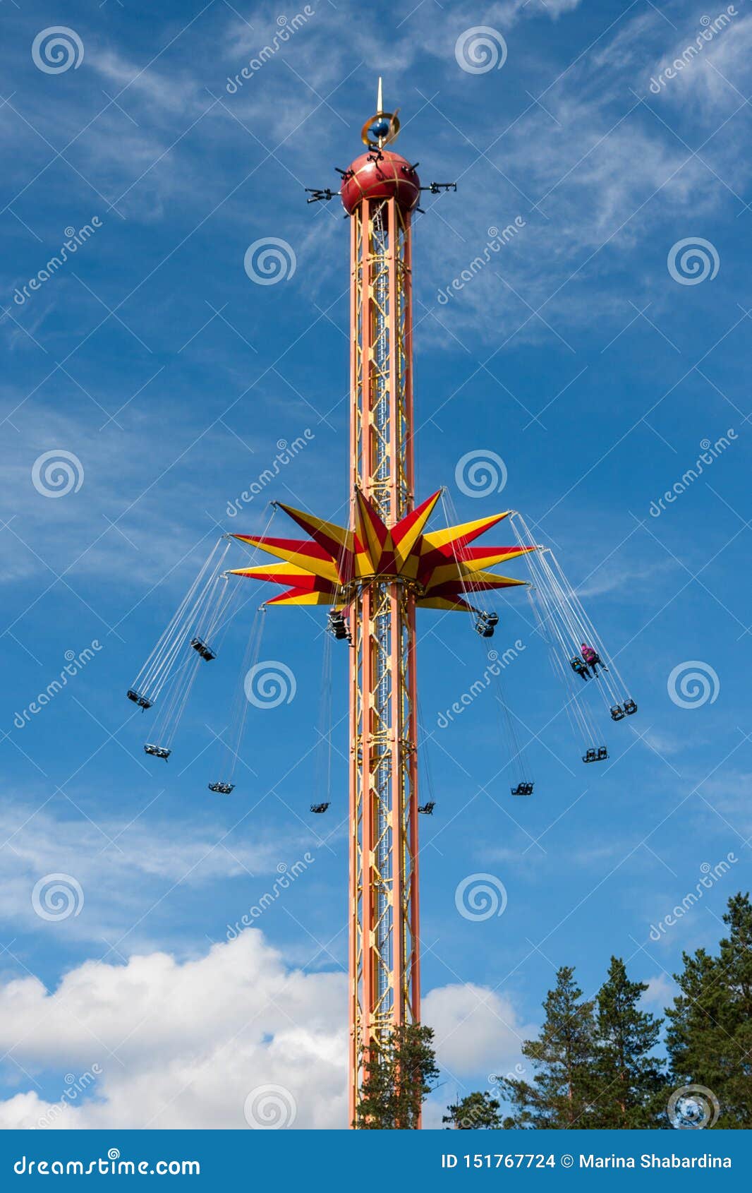 High Attraction Rotating Swings Against A Blue Sky In Clear Weather