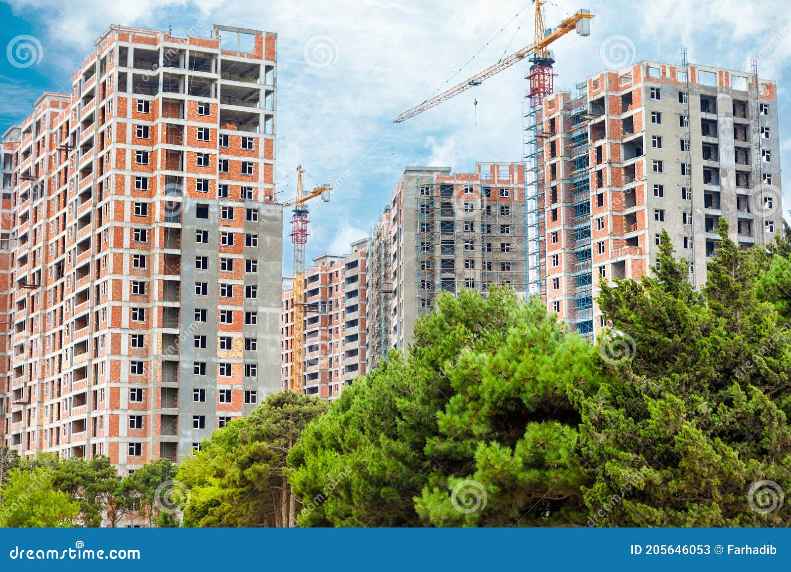 High Buildings with Scaffold and Green Trees at the Construction Site ...