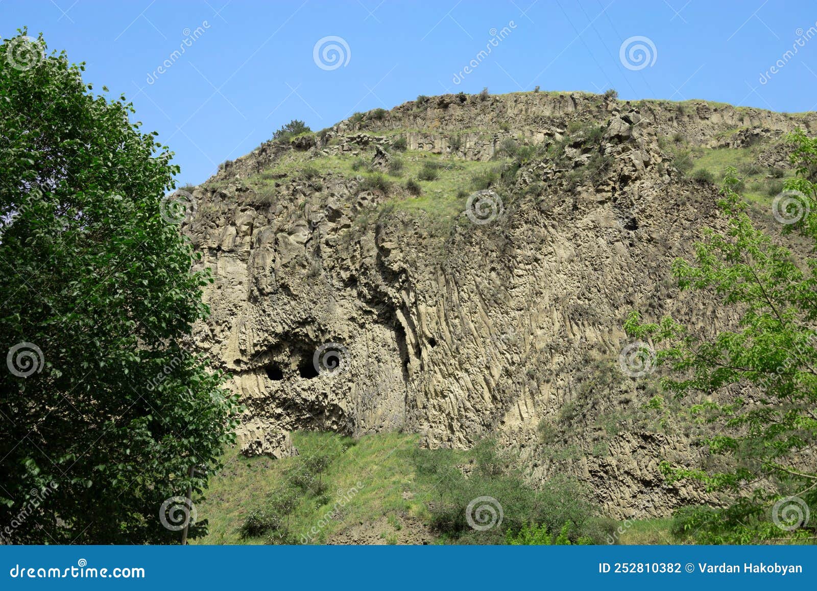 High Cliff with Caves, with Grass and Foliage Stock Photo - Image of ...
