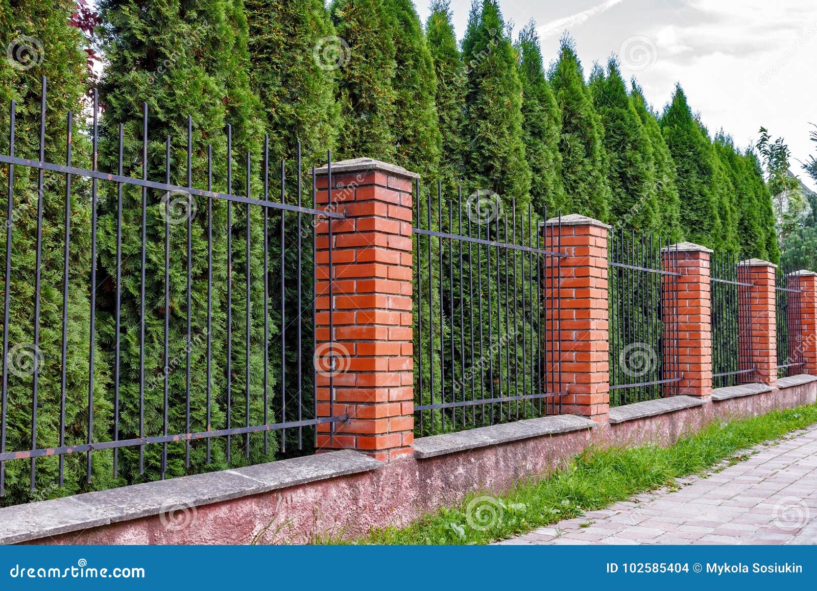 High Fence with Brick Columns. Black Railings and Brick Wall Stock ...