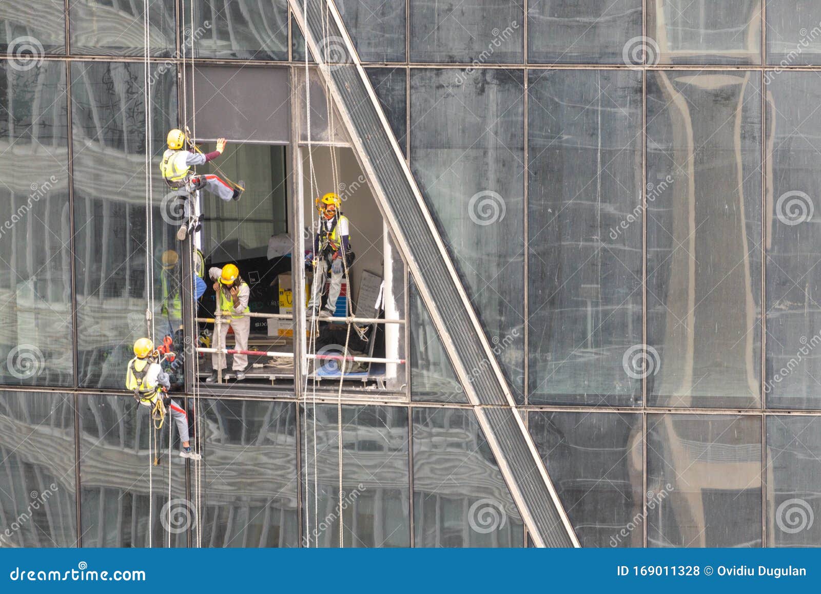 High Maintenance Workers Installing a Window on the Exterior of a ...