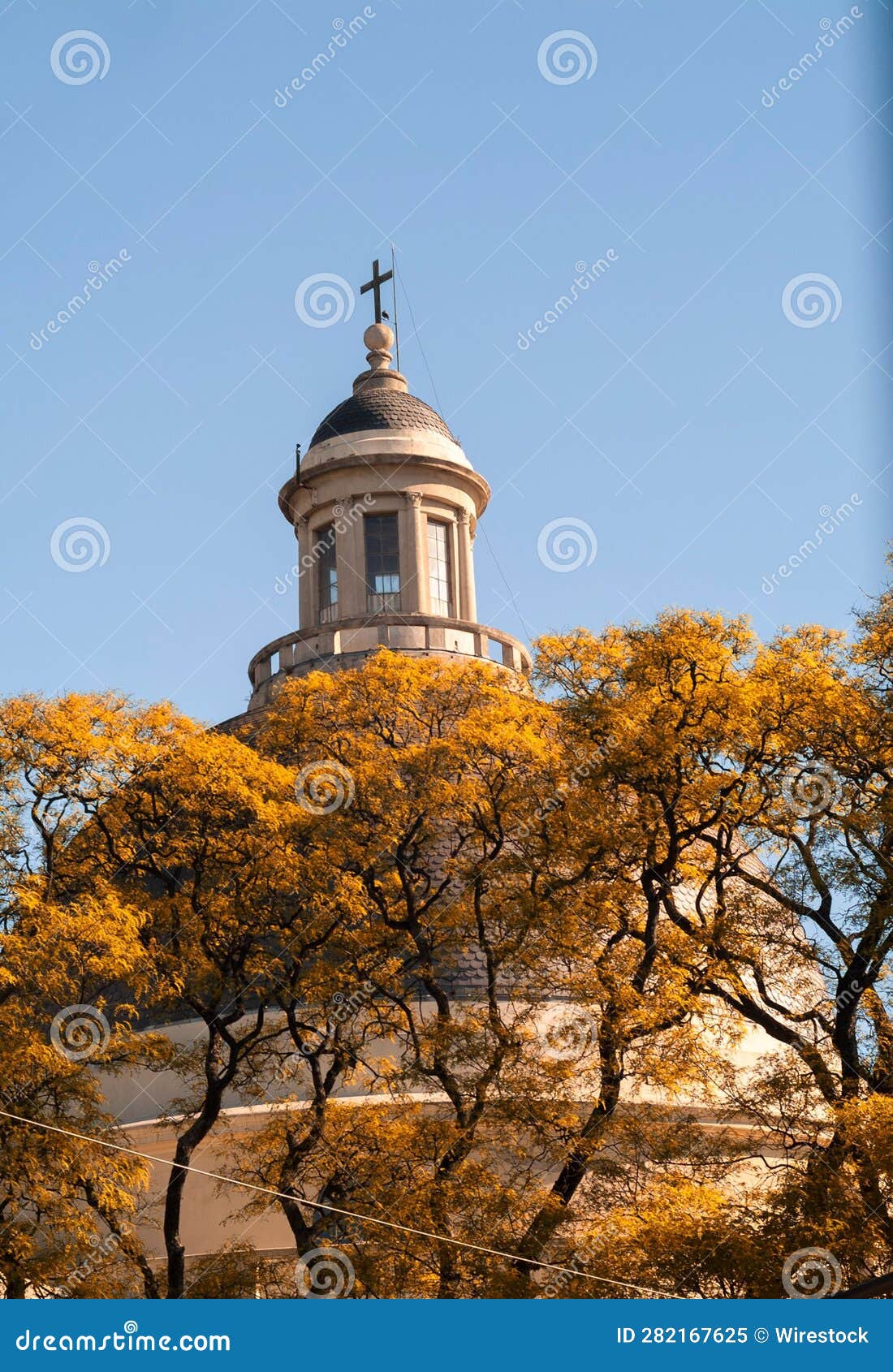 High-rise Church with a Clock Tower Surrounded by a Tree on a Blue Sky ...