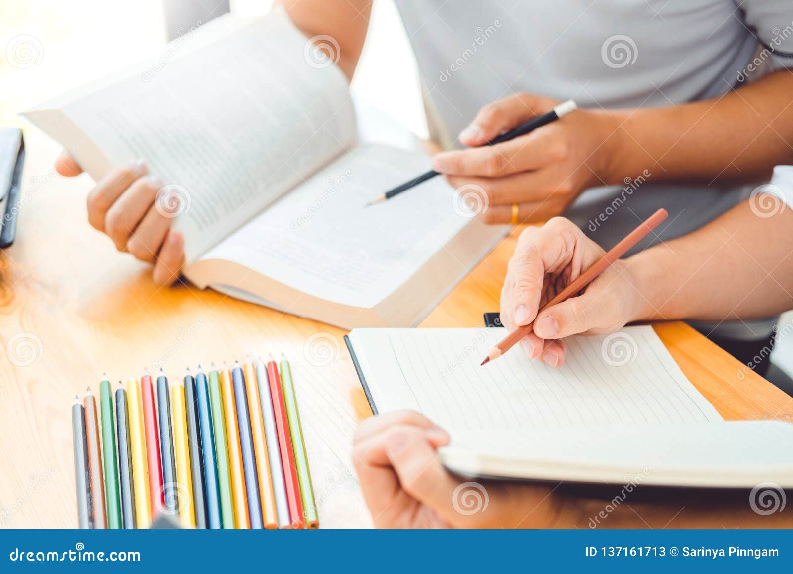 High School or College Students Studying and Reading Together in ...