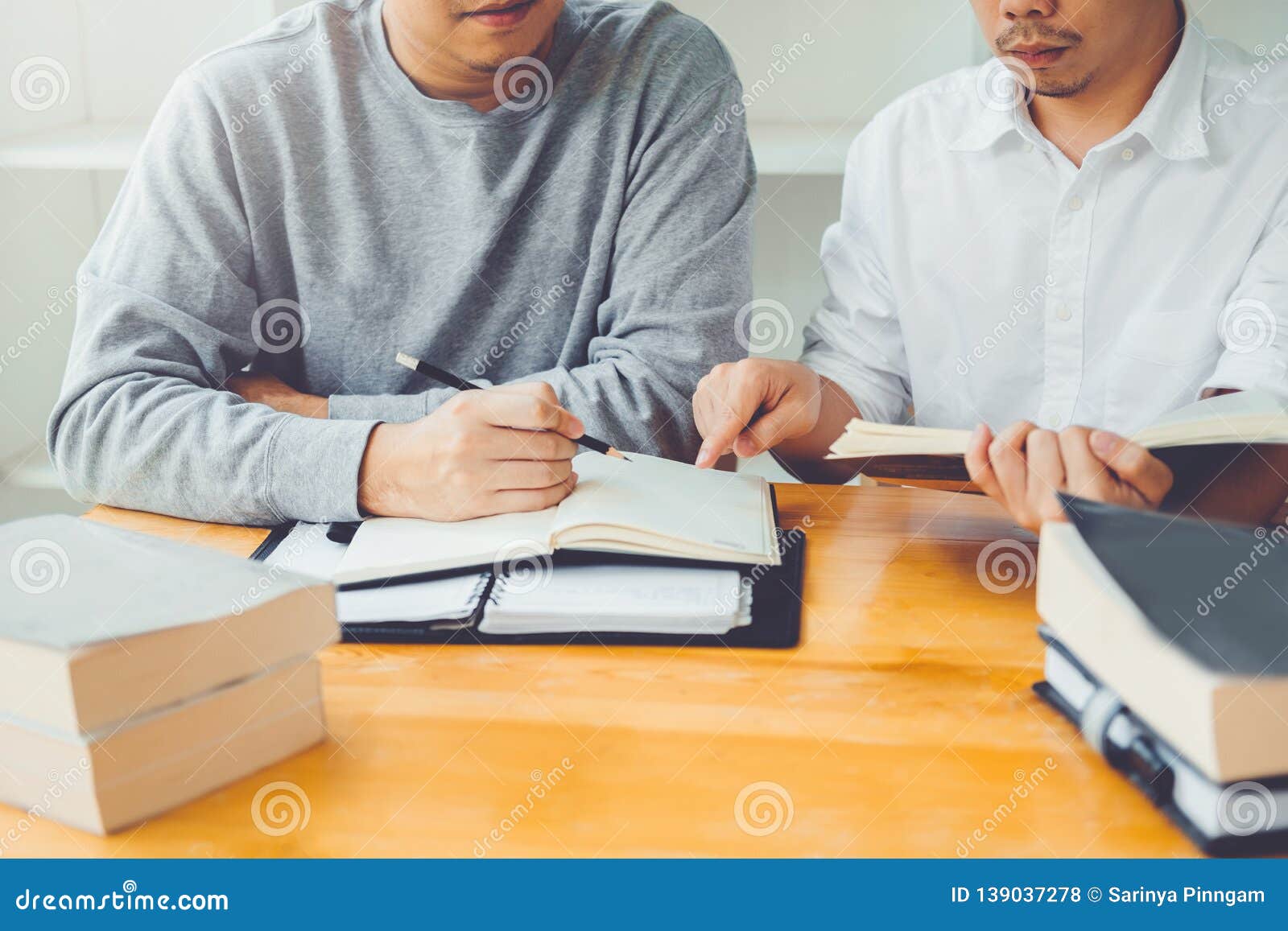 High School or College Students Studying and Reading Together in ...