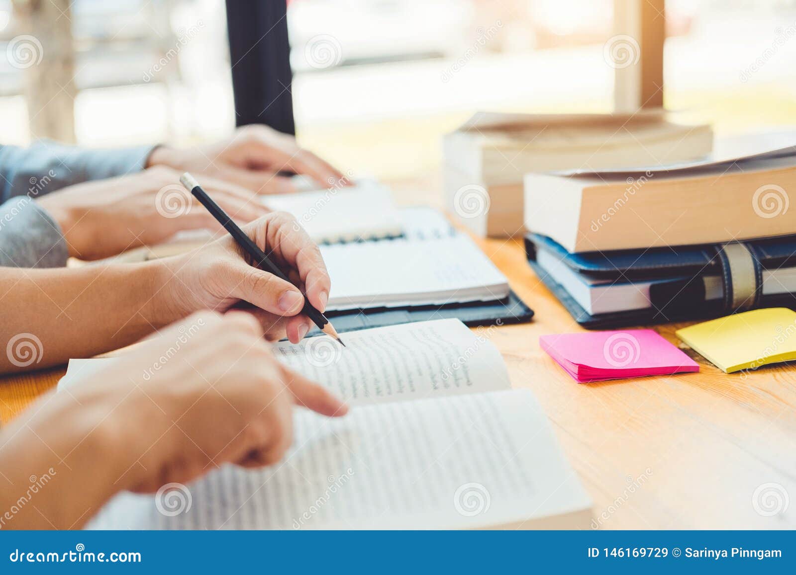 High School or College Students Studying and Reading Together in ...