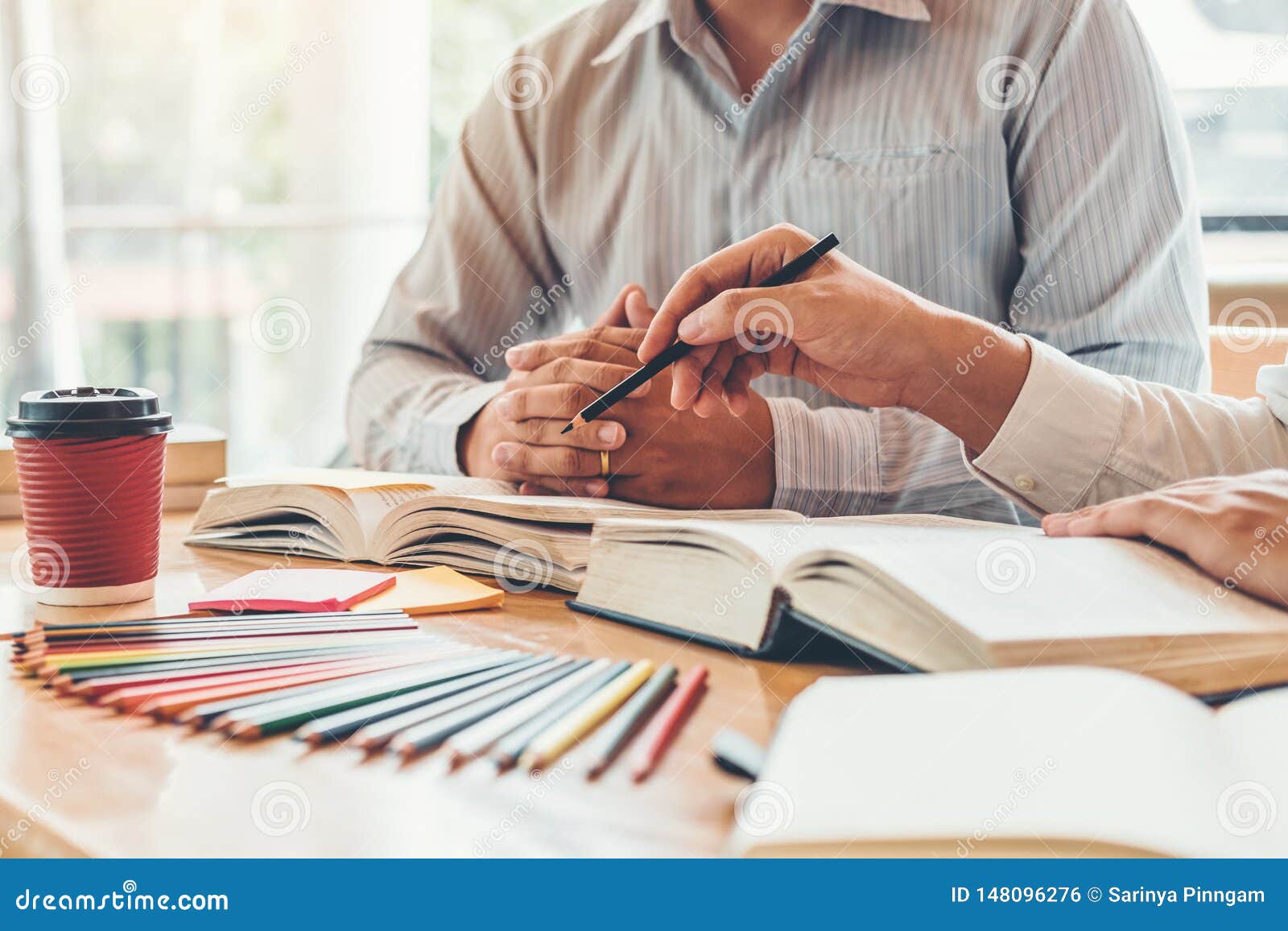 High School or College Students Studying and Reading Together in ...