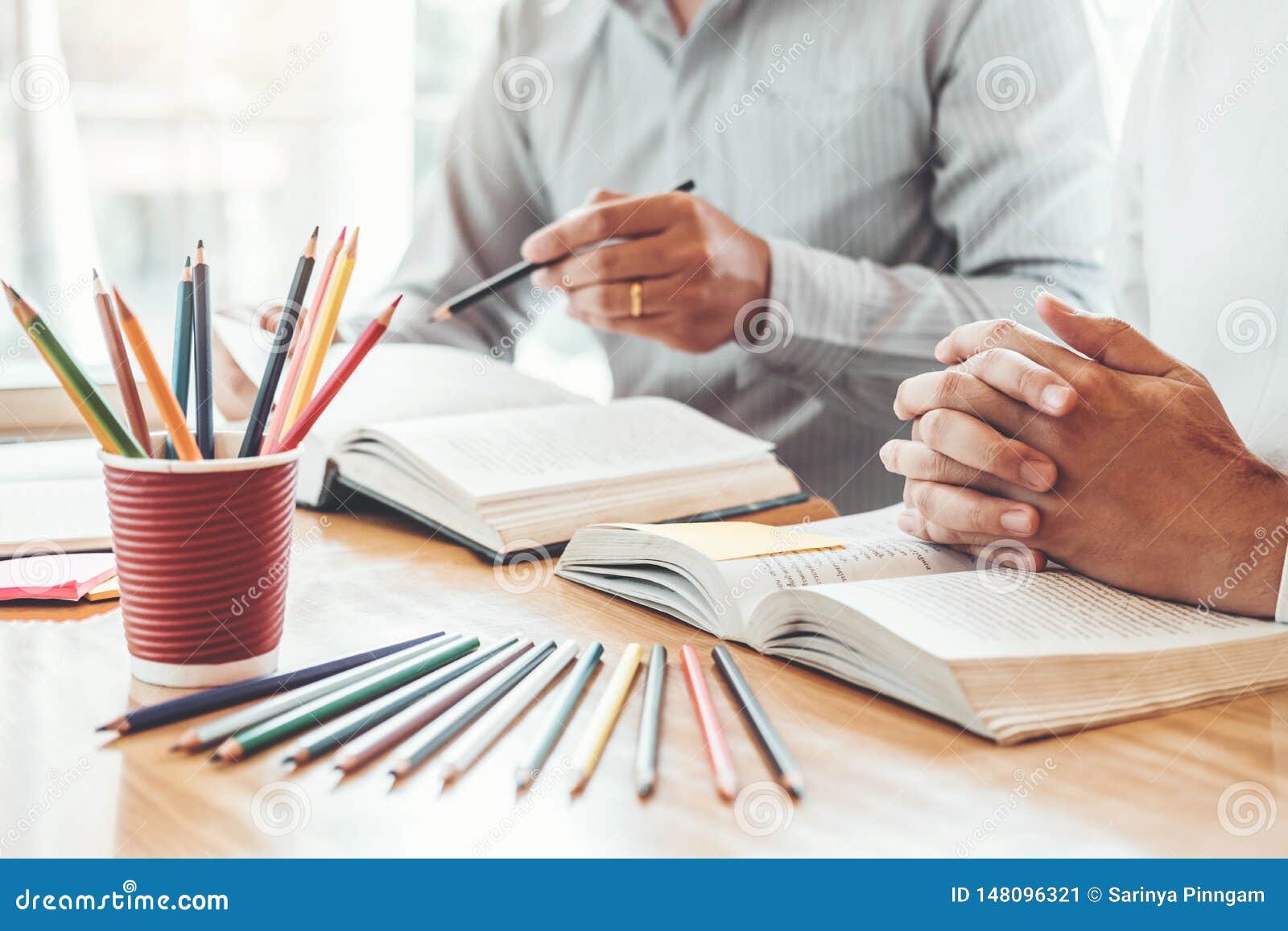 High School or College Students Studying and Reading Together in ...