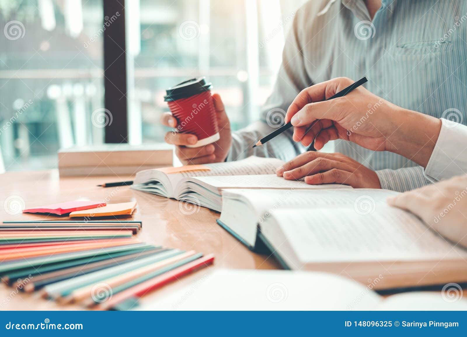High School or College Students Studying and Reading Together in ...