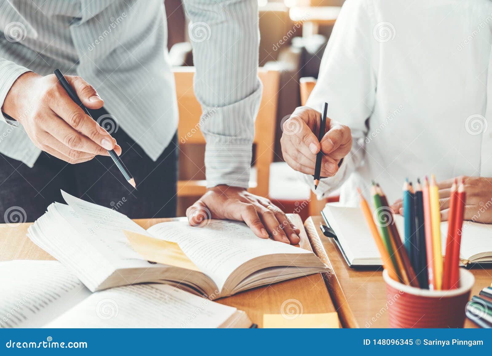 High School or College Students Studying and Reading Together in ...