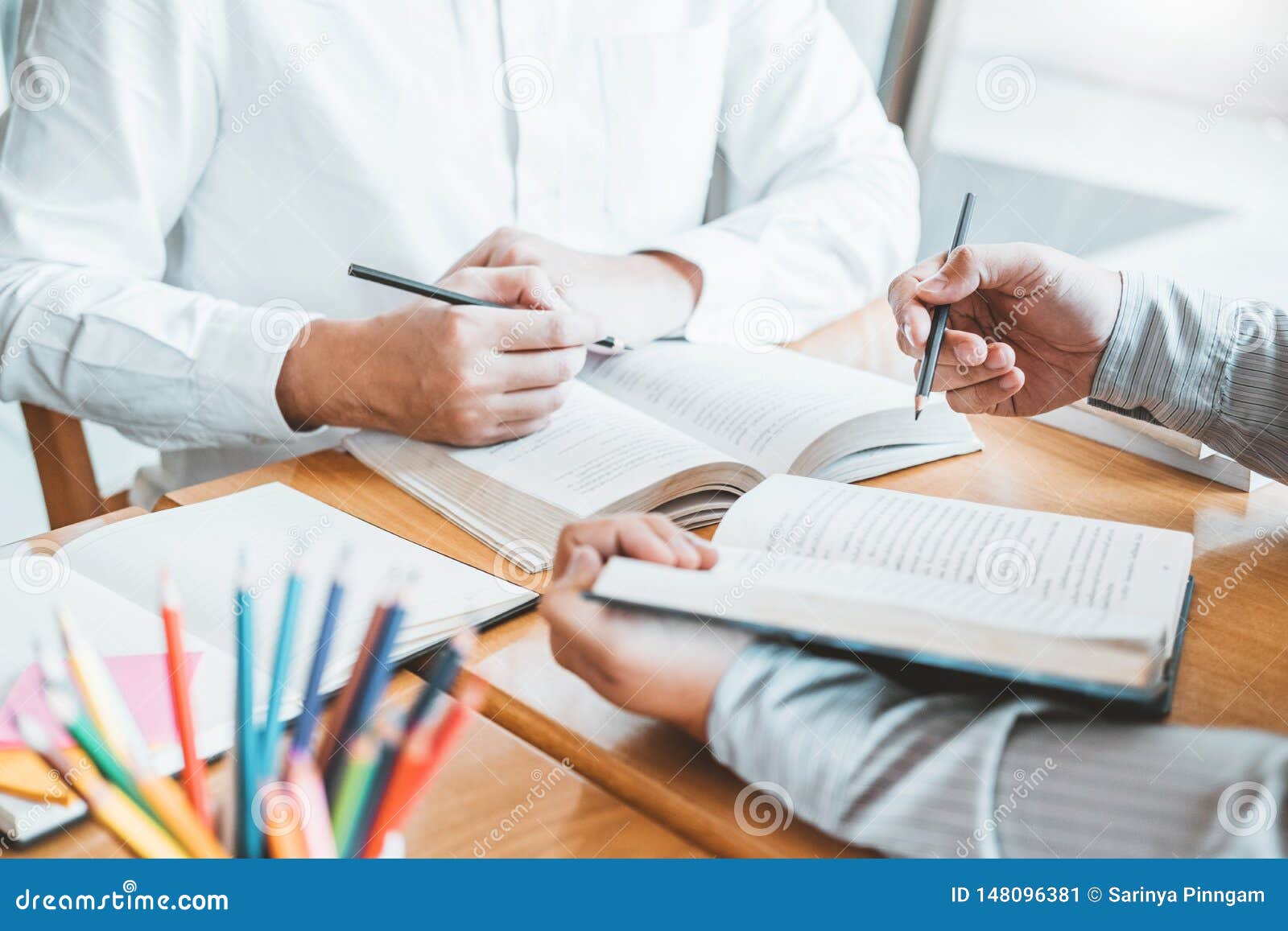 High School or College Students Studying and Reading Together in ...
