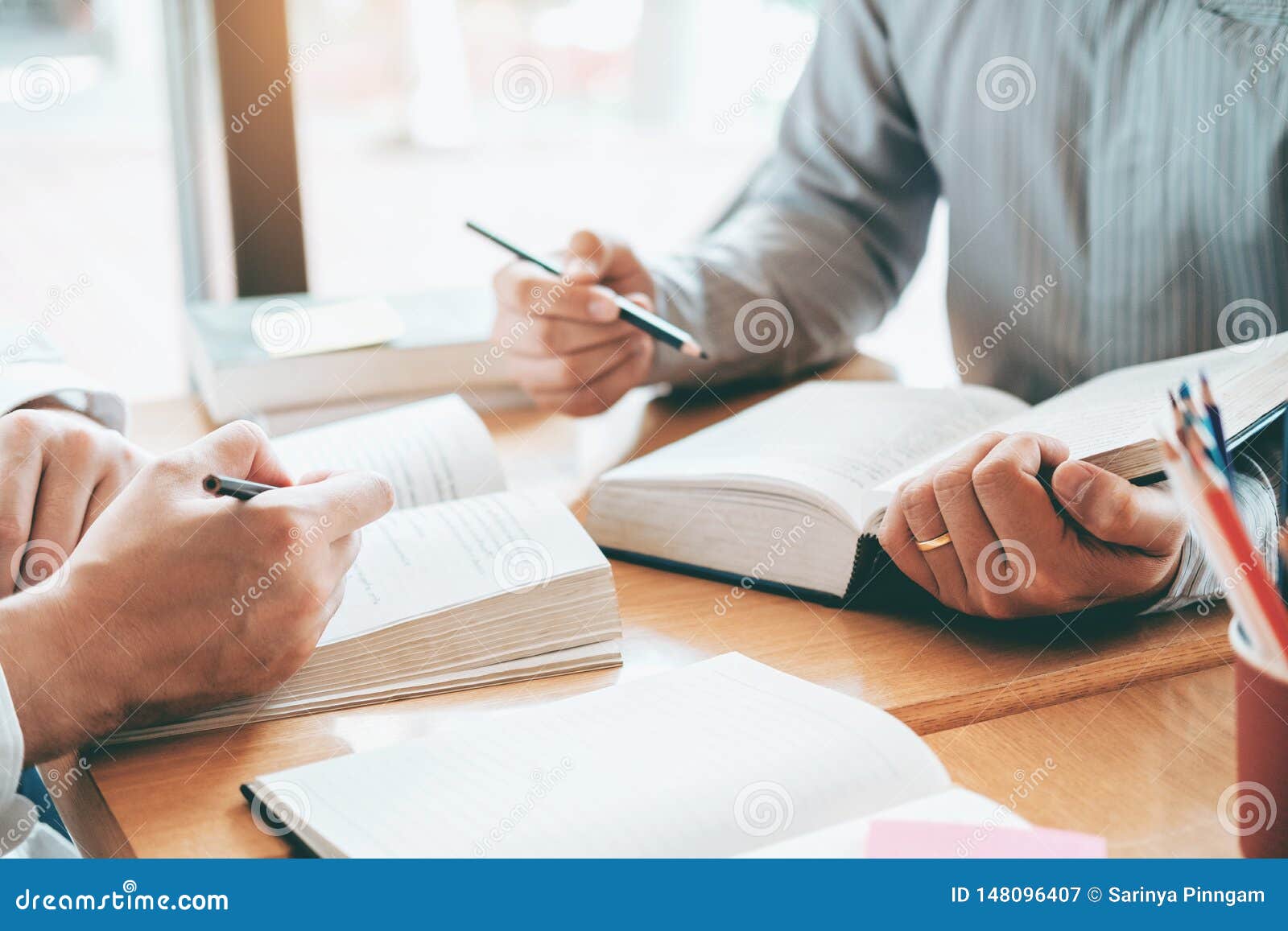 High School or College Students Studying and Reading Together in ...
