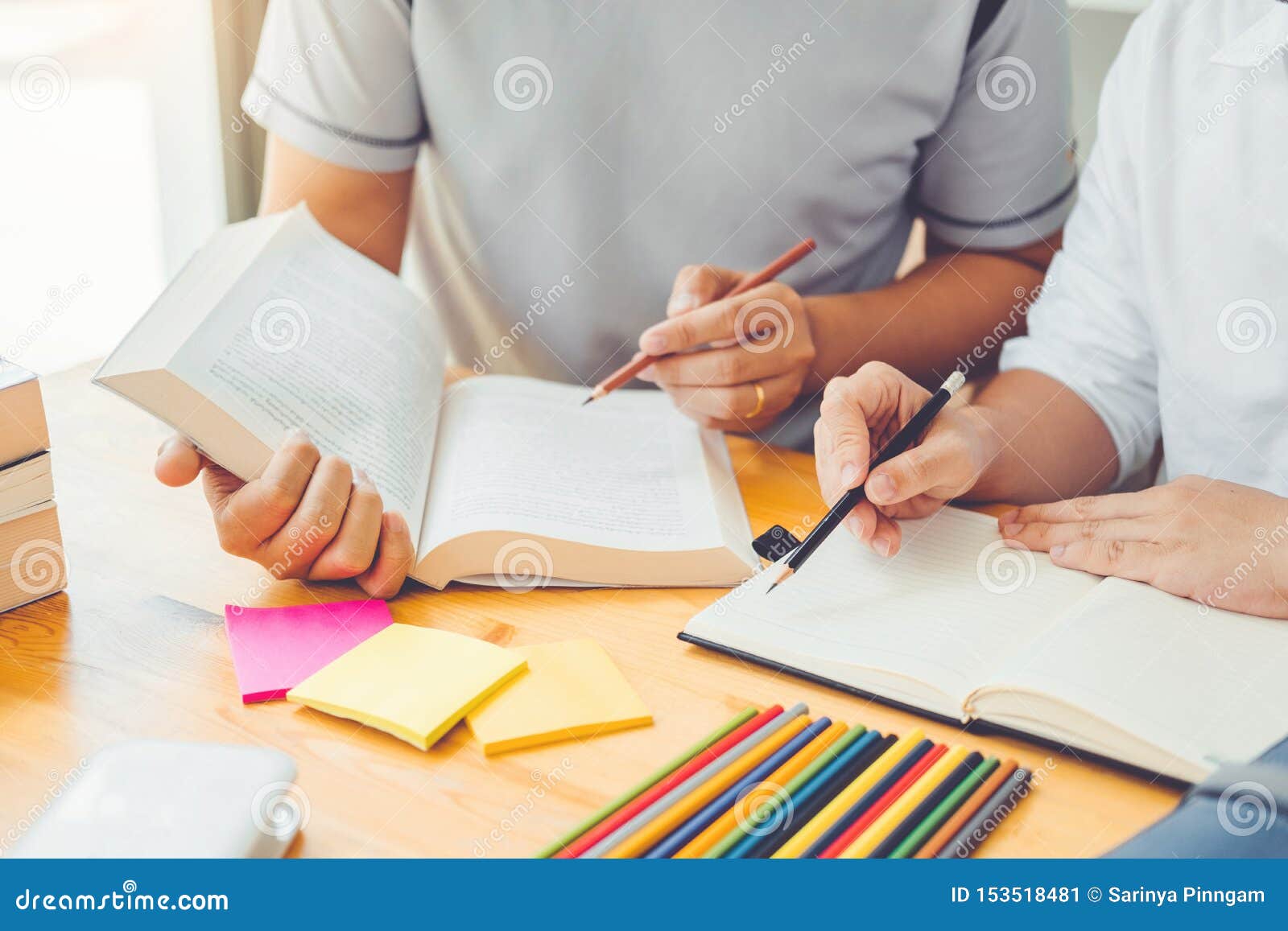 High School or College Students Studying and Reading Together in ...