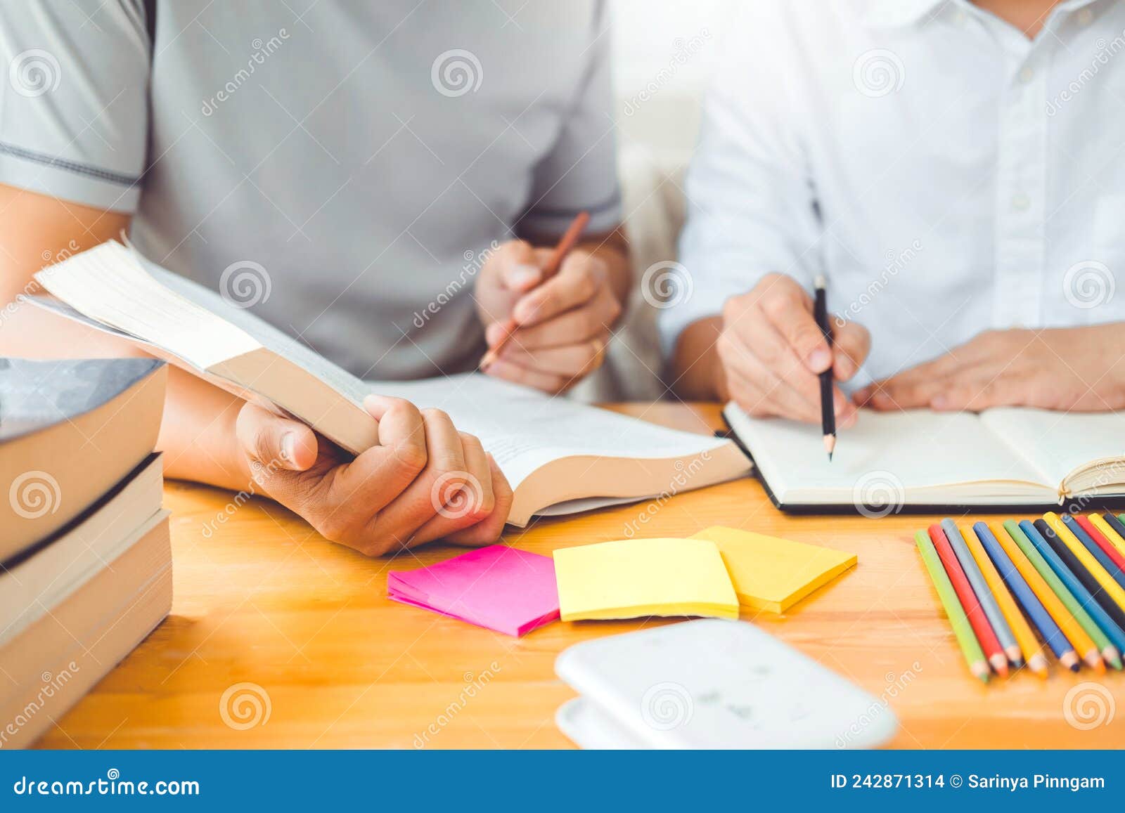 High School or College Students Studying and Reading Together in ...