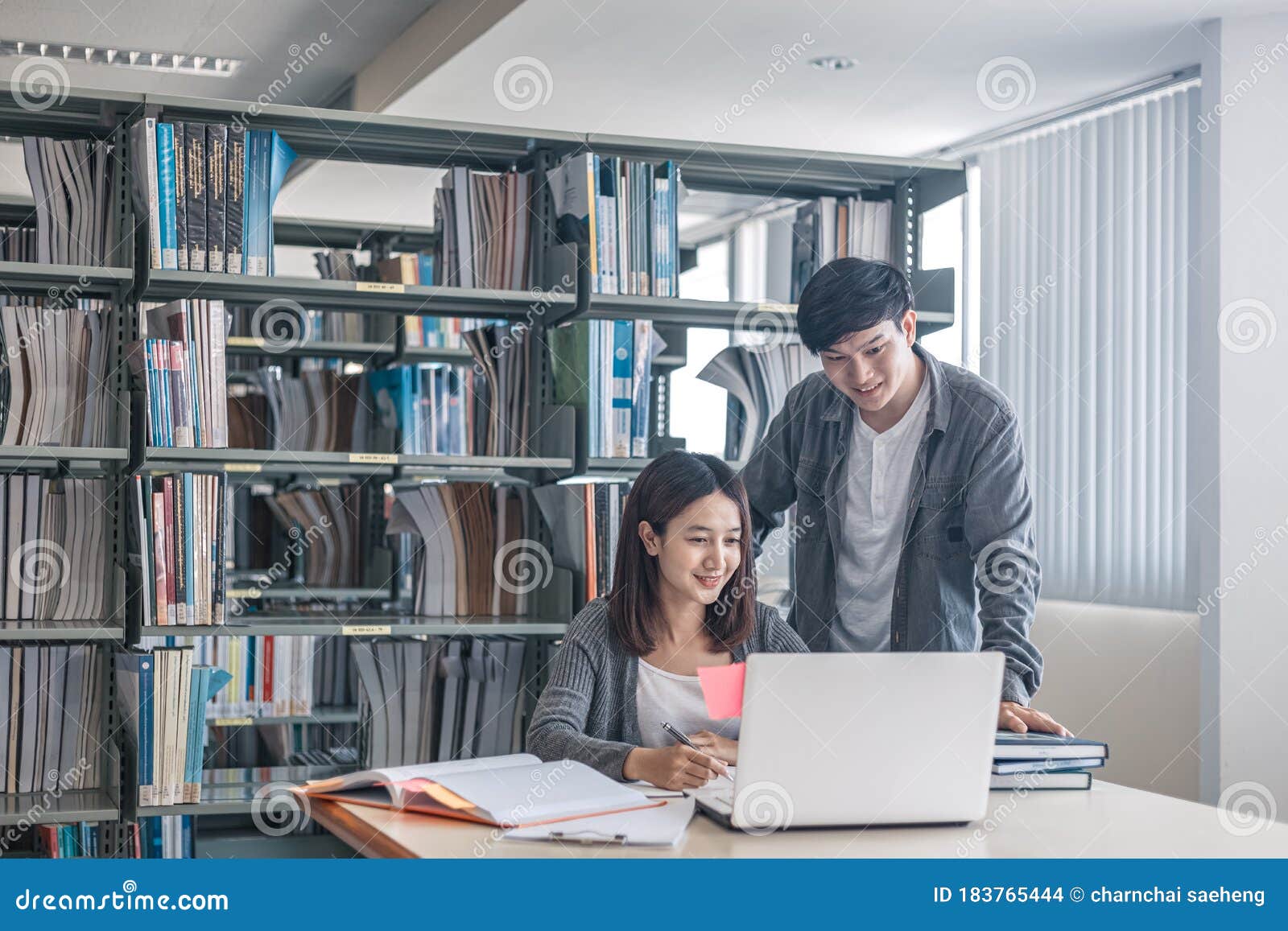 High School or College Students Studying and Reading Together in ...