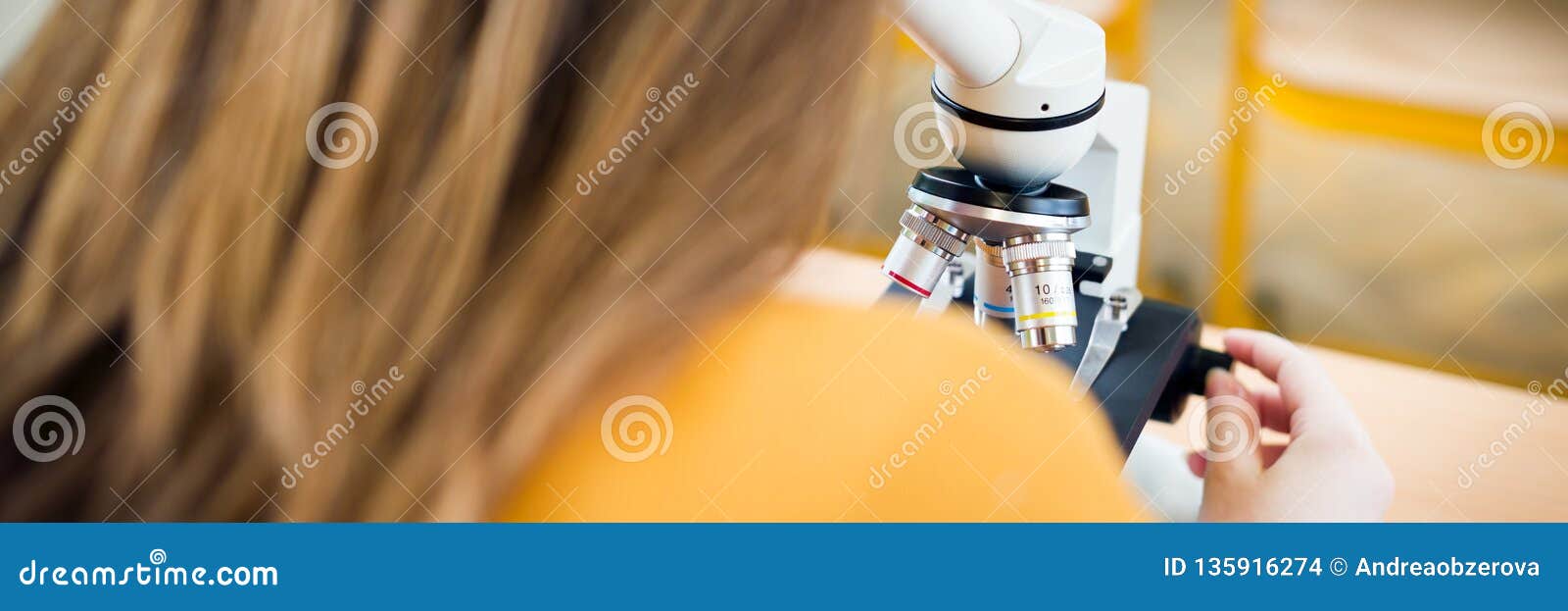 High School Female Student in Biology Class. Student Using Microscope ...