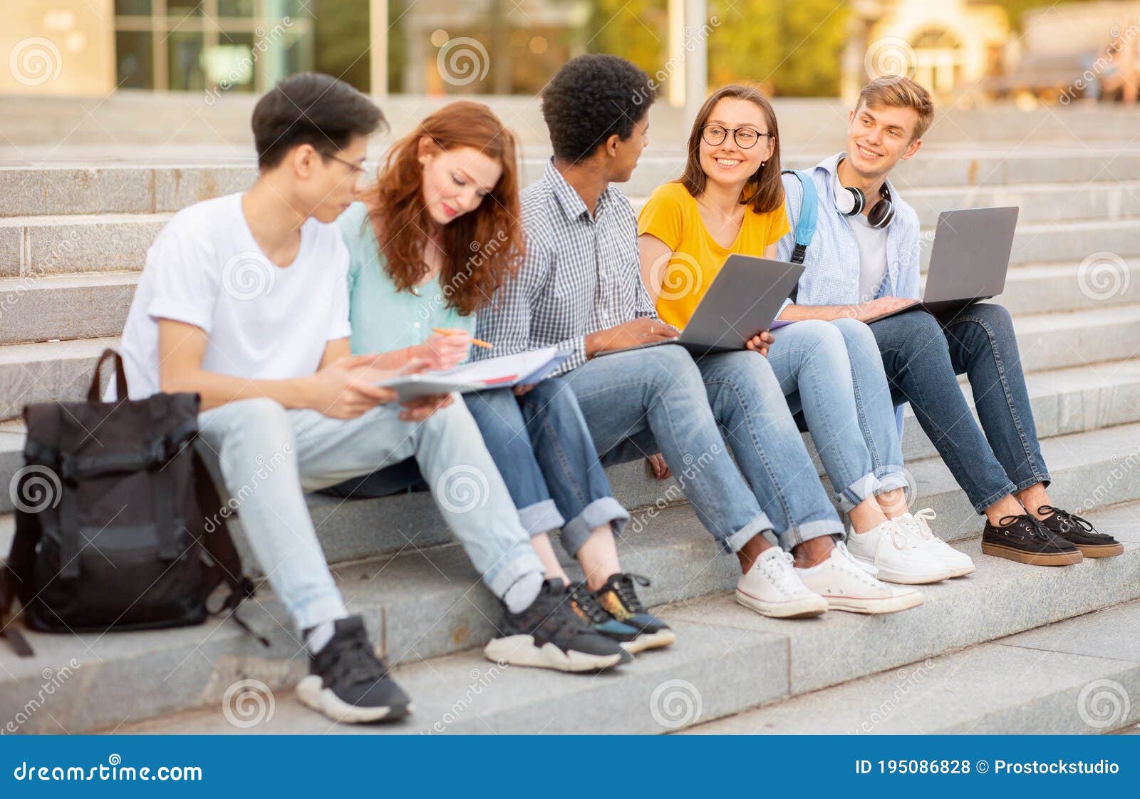 High-School Students Doing Homework Together Sitting on Steps Outside ...